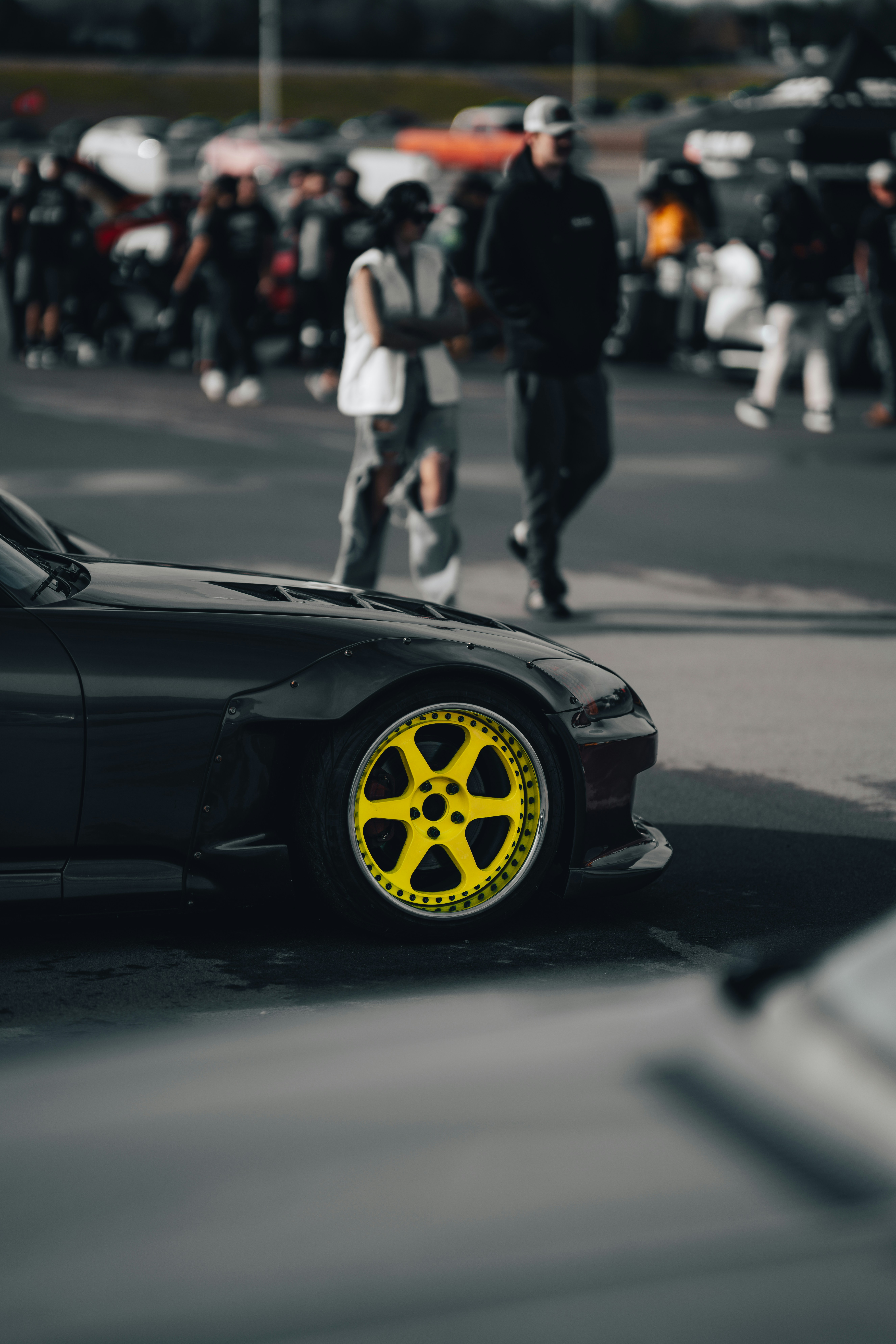 Neon-yellow wheels anchor a midnight stance in a blur of crowd