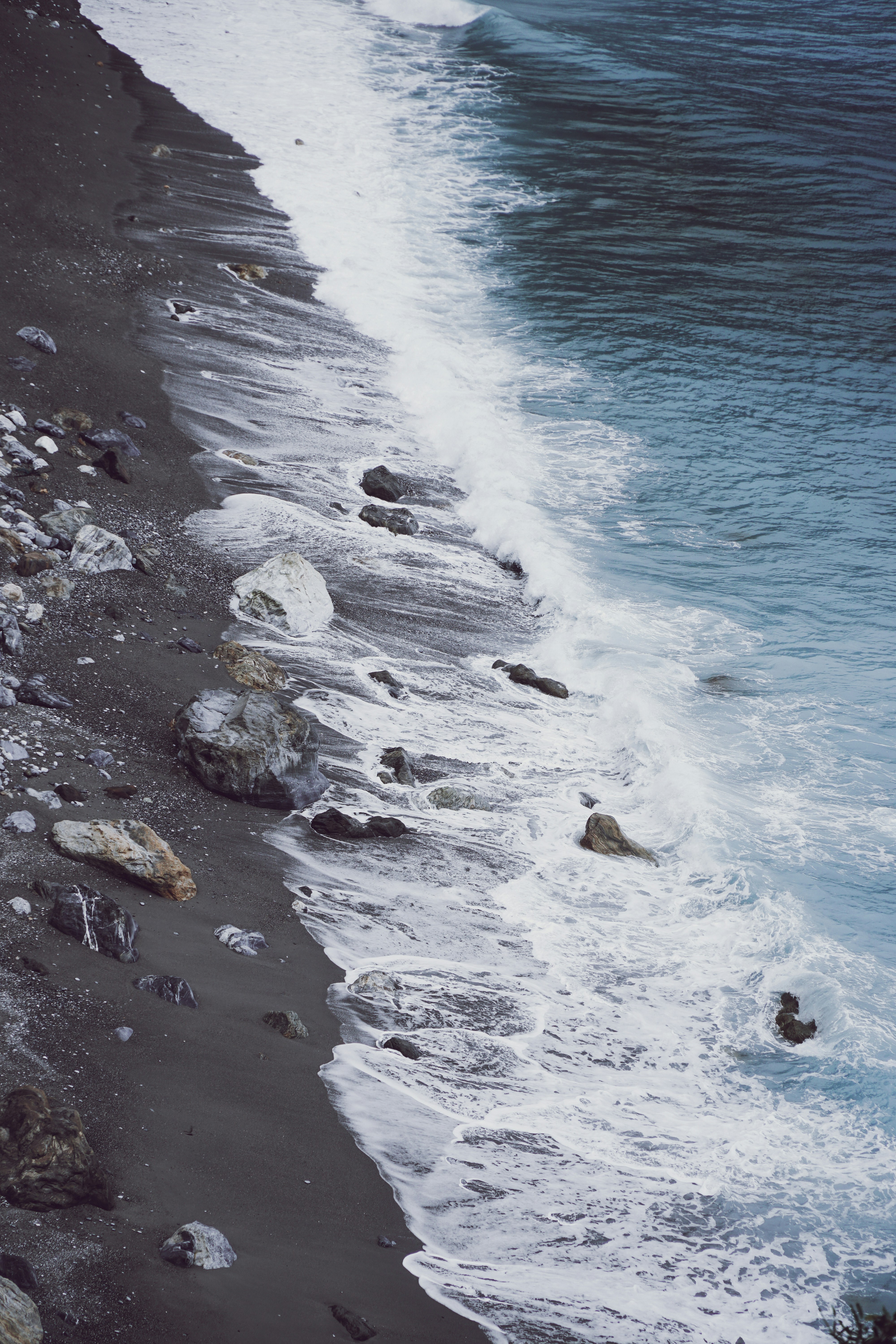 Pebbled Shoreline Swoon: Waves Reclaiming the Dark Beach