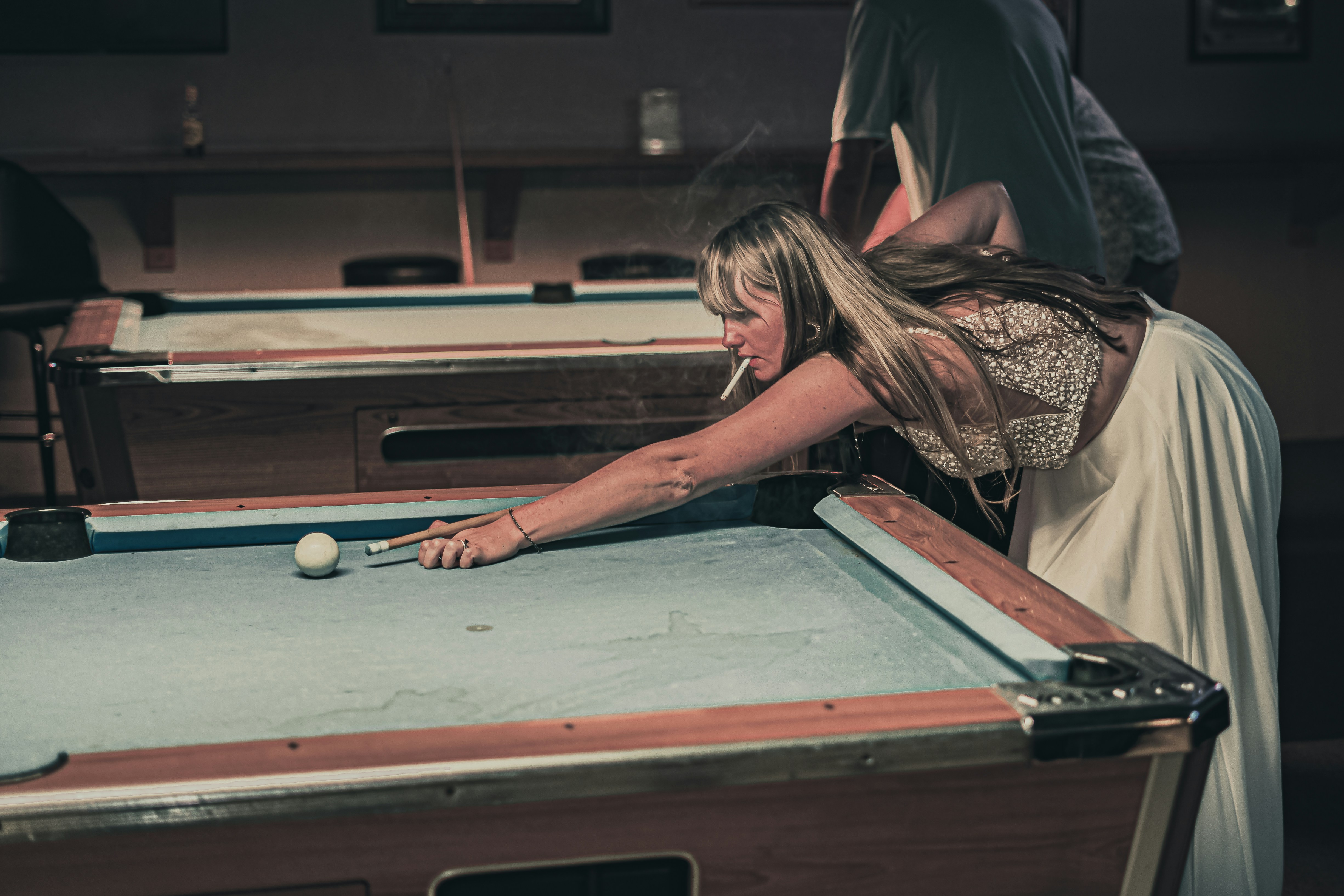 A woman leaning over a pool table to hit a ball photo – Free Orlando ...