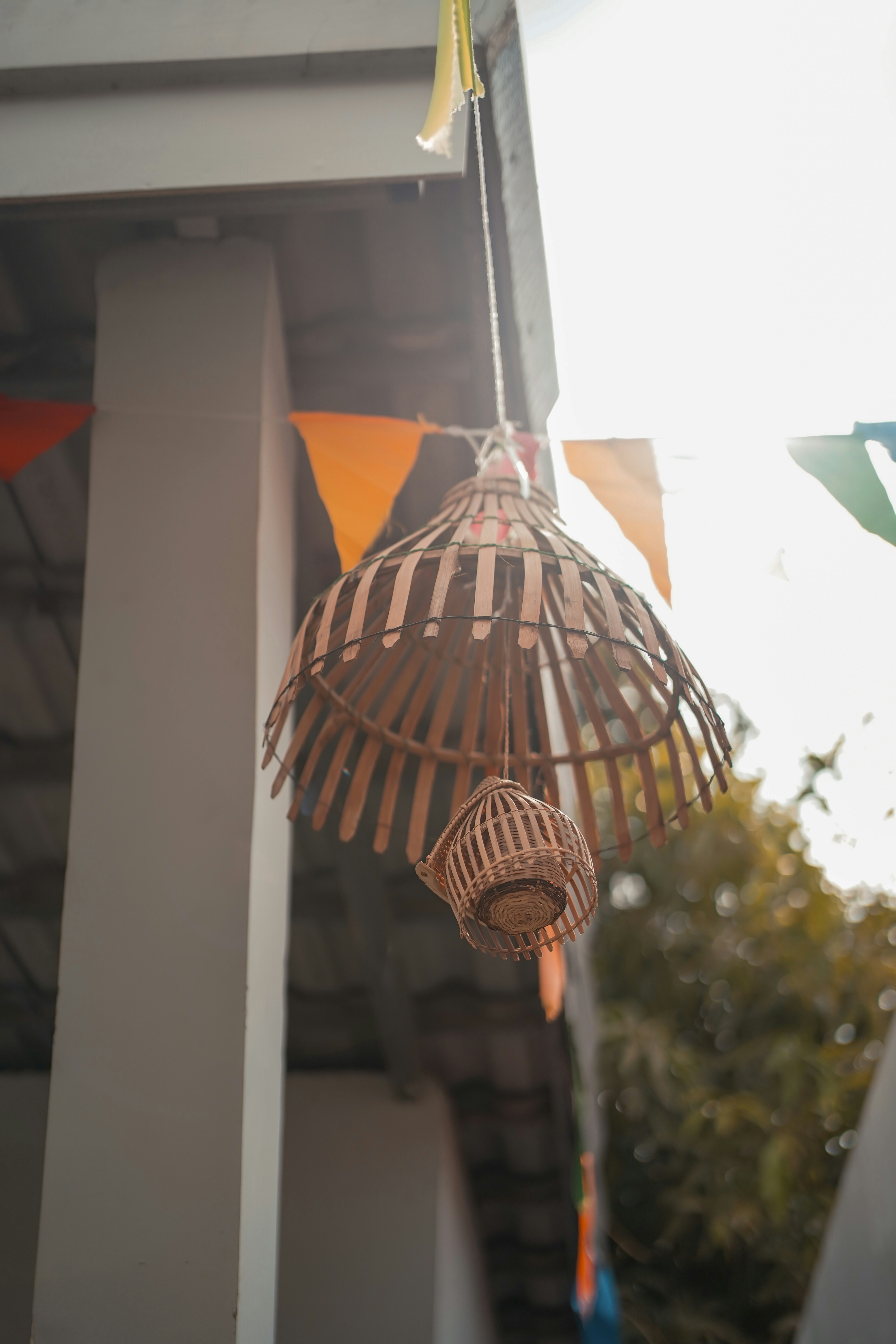Twin wicker lanterns under festive bunting in warm afternoon light