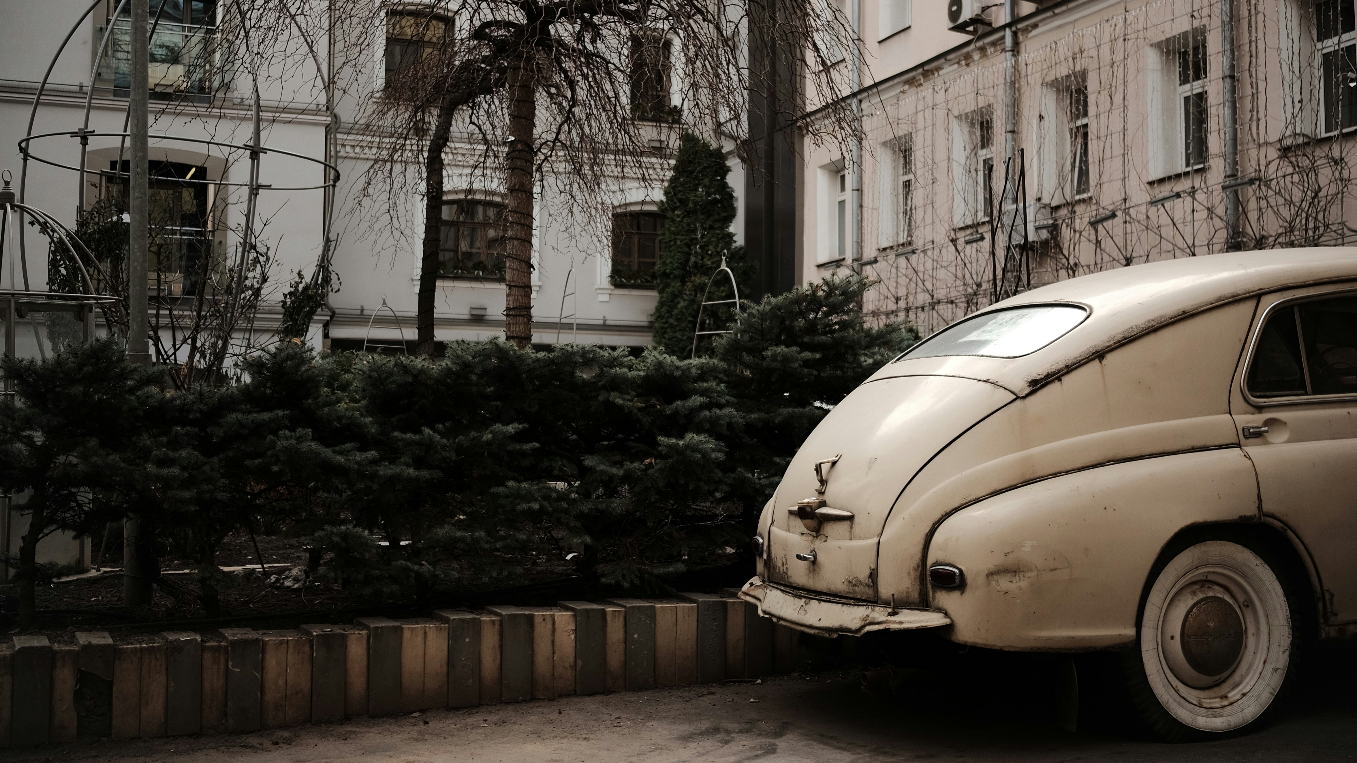 Monochrome Calm: A Vintage Sedan Pauses at a Quiet City Street