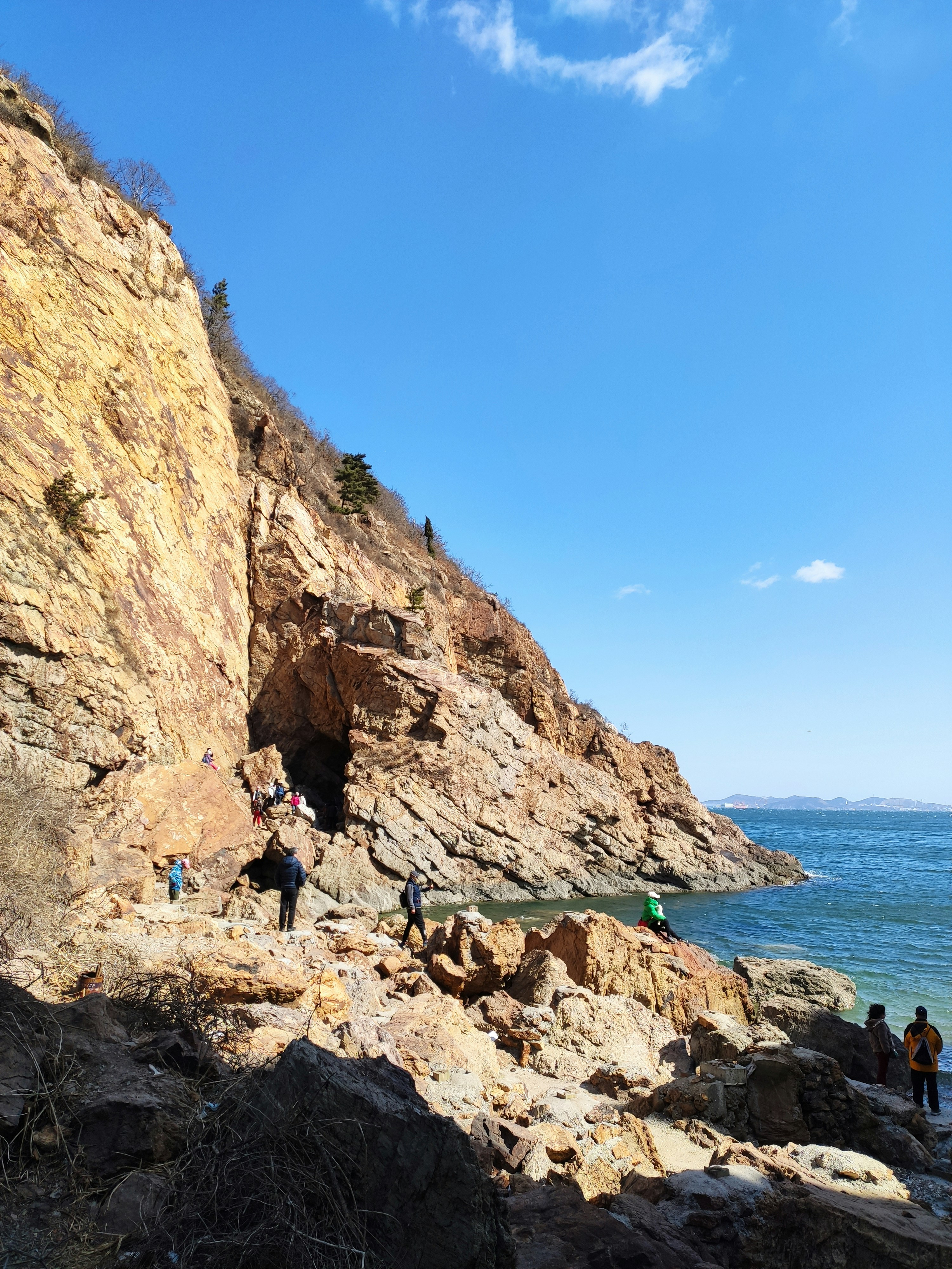 A group of people climbing up the side of a cliff photo – Free Sea ...