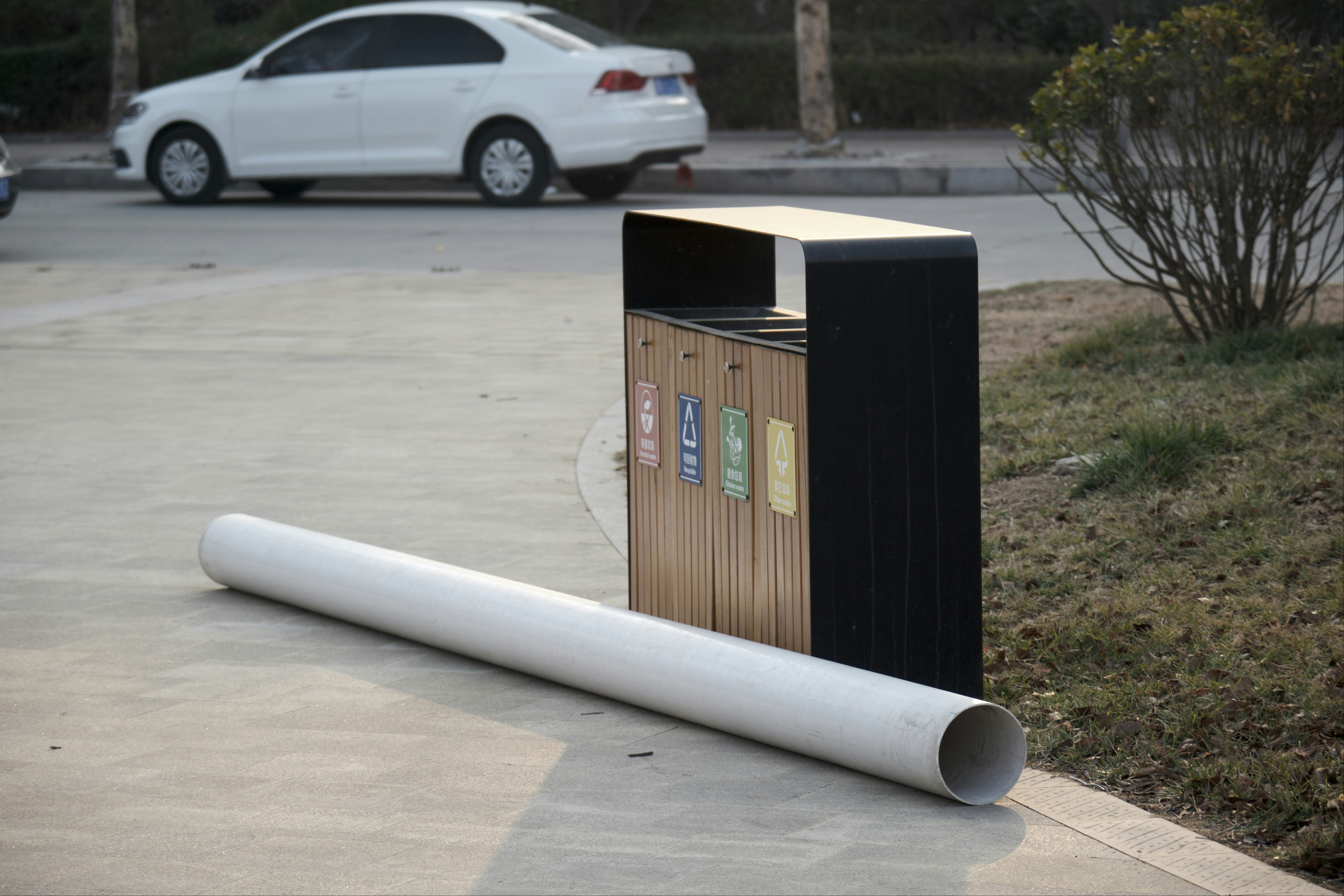 Leaned Pipe, Upright Bin: A Quiet Urban Study in Color and Form