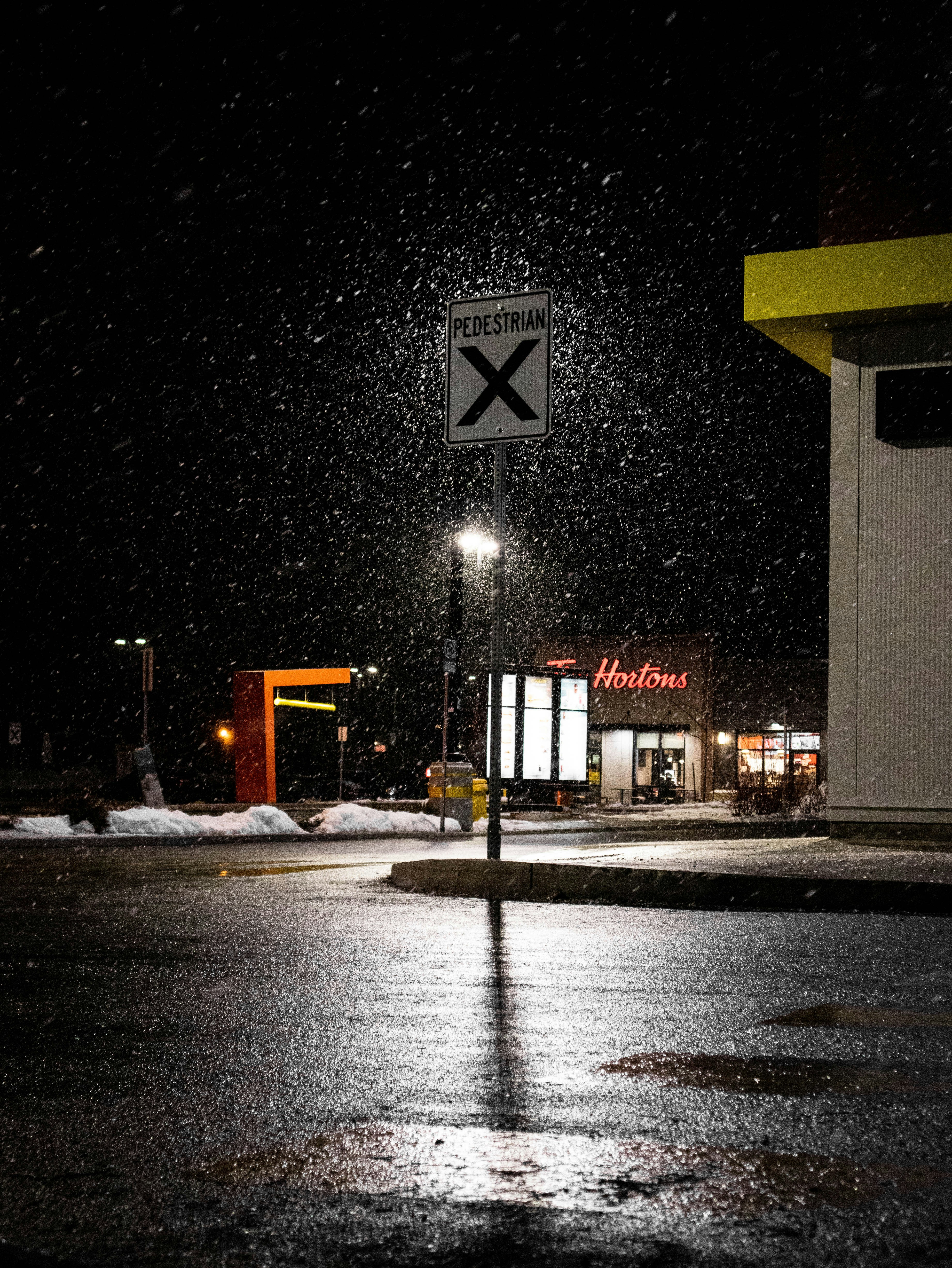 A crosswalk sign in the snow at night photo – Free City Image on Unsplash