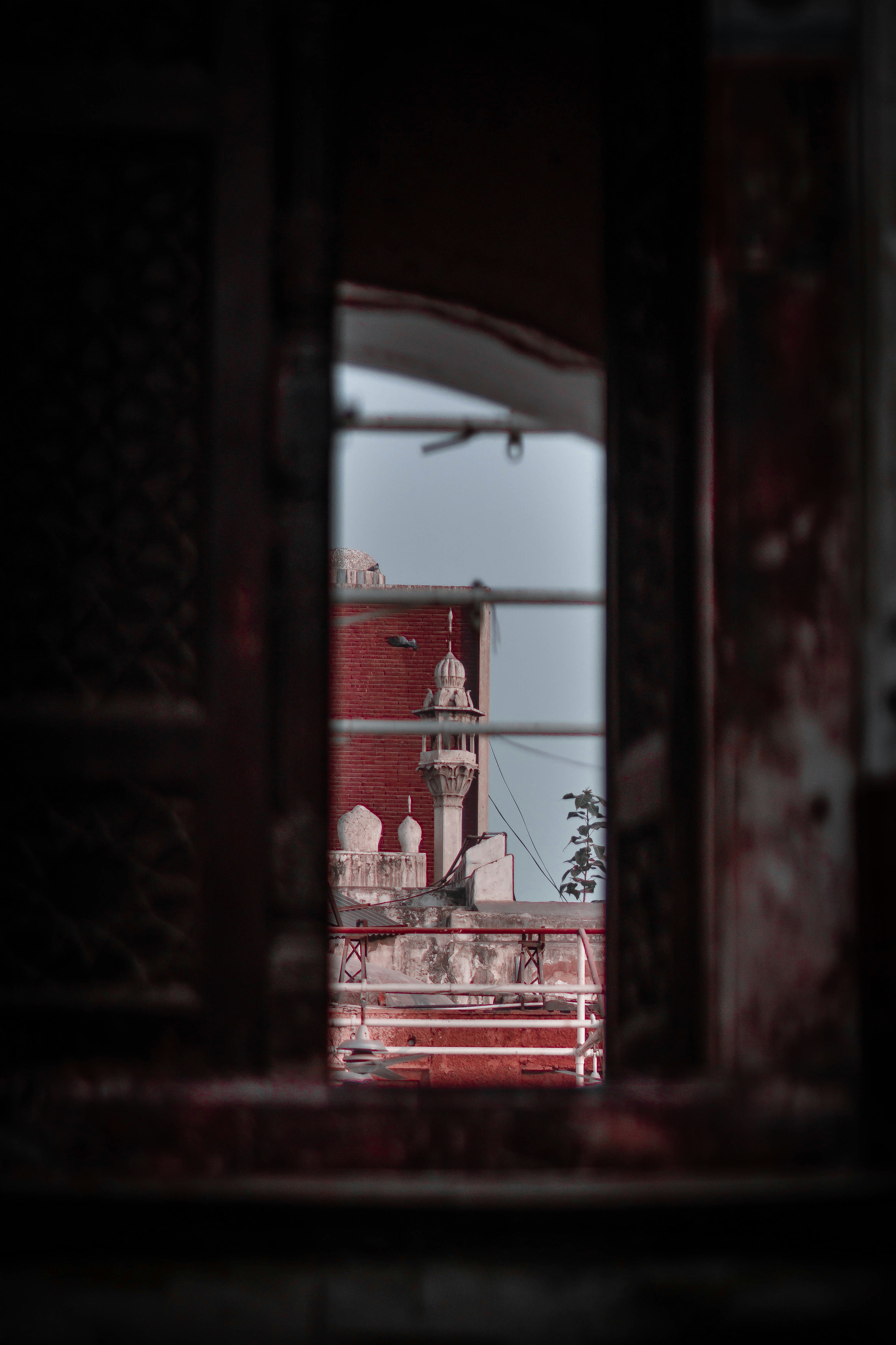 Through the Grilles: A Shrine Emerges in a Narrow Window