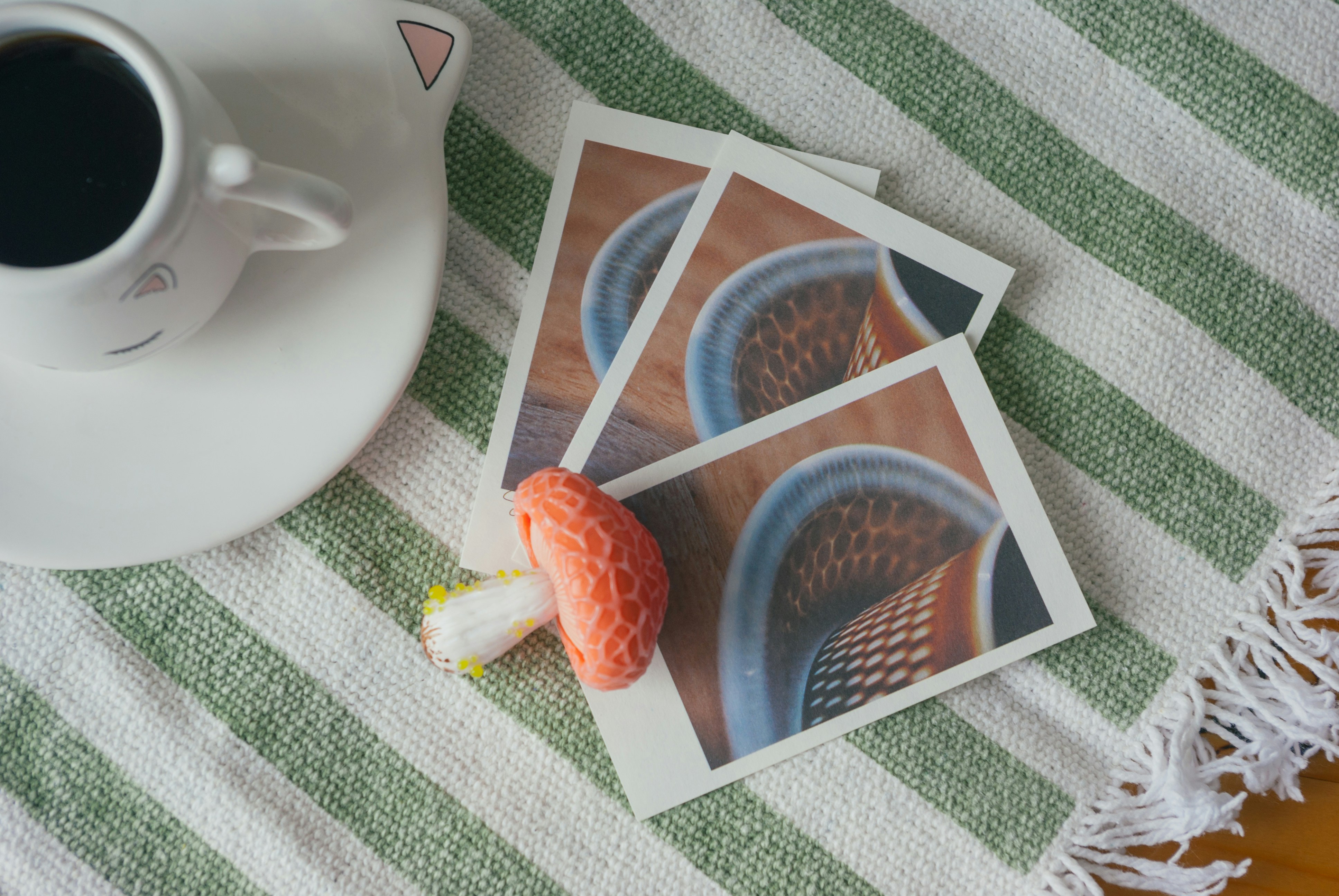 Polaroid Spread Over a Green-Striped Cloth with a Cup of Coffee