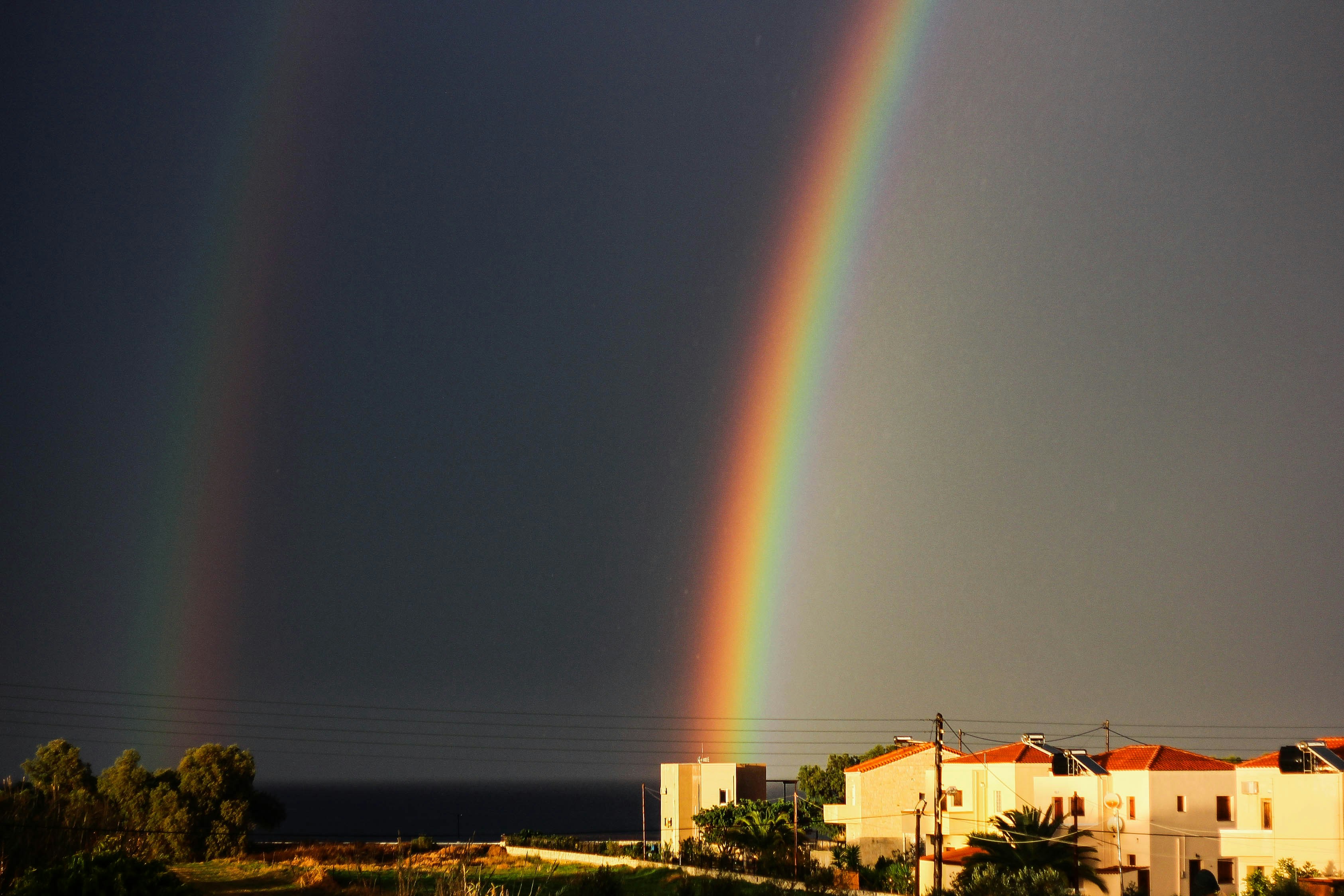 two rainbows in the sky over a town