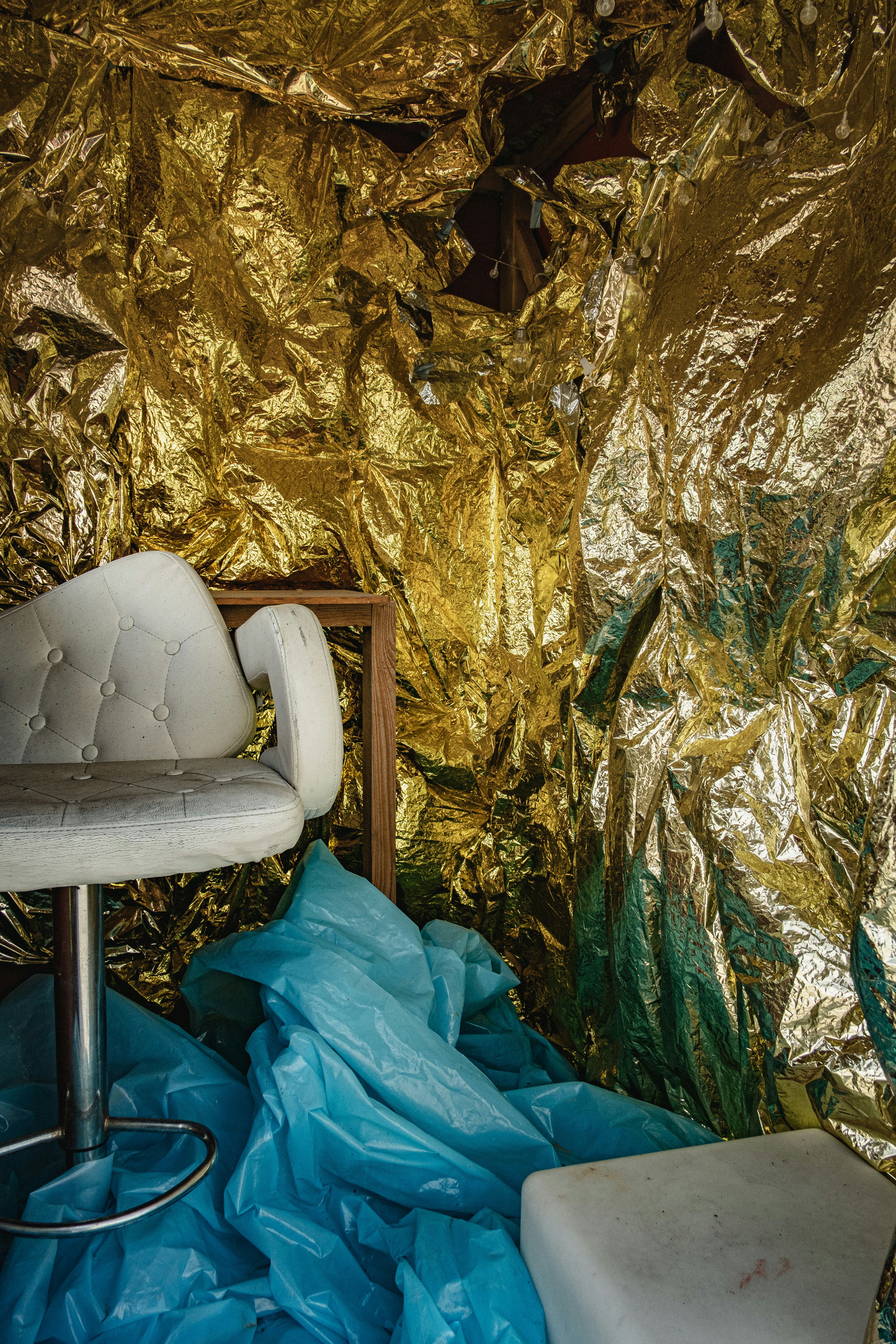 Gilded Nook: A Lone Chair Amid Crumpled Gold