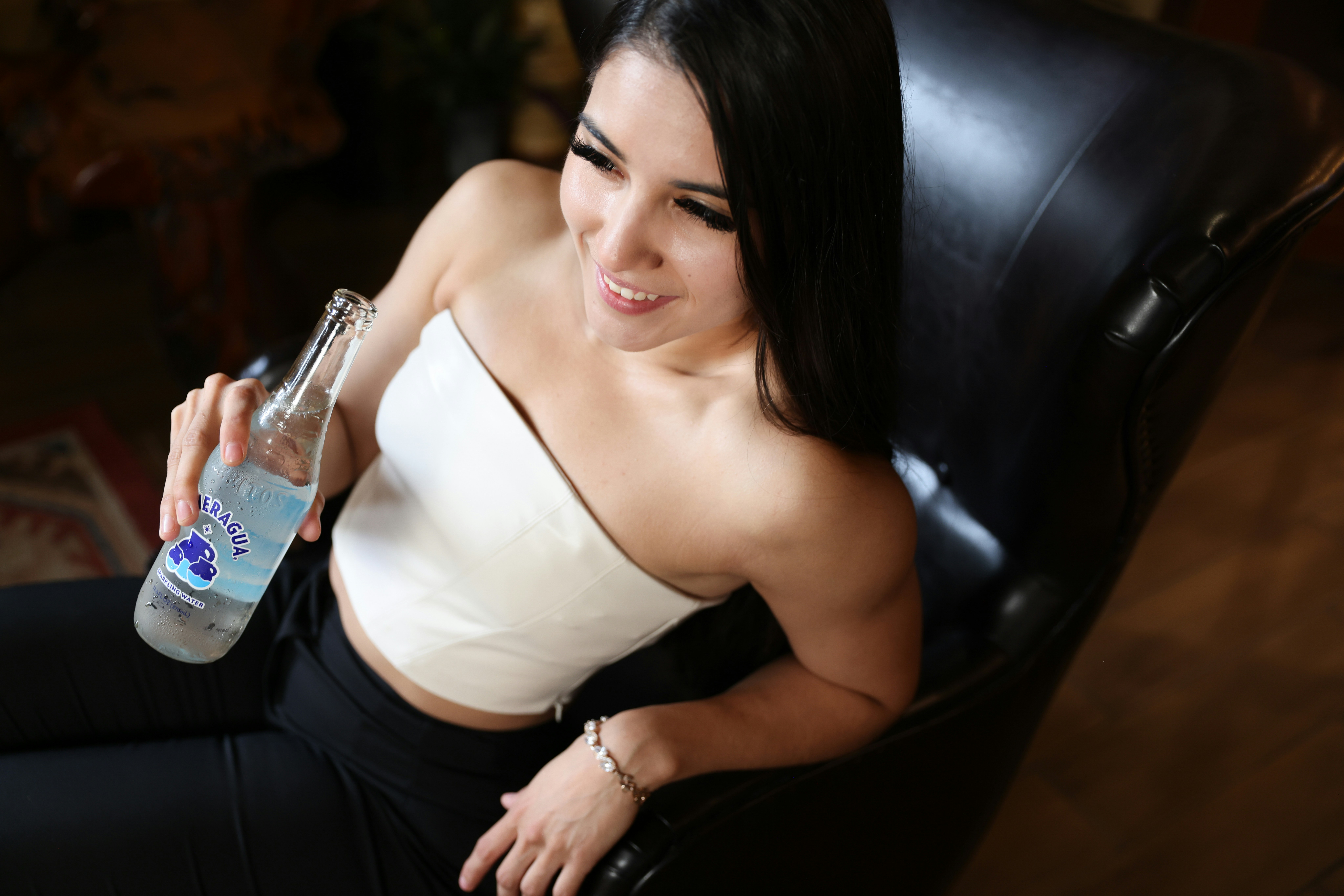 Lounge Portrait in Warm Light: Poise, White Top, and a Bottle