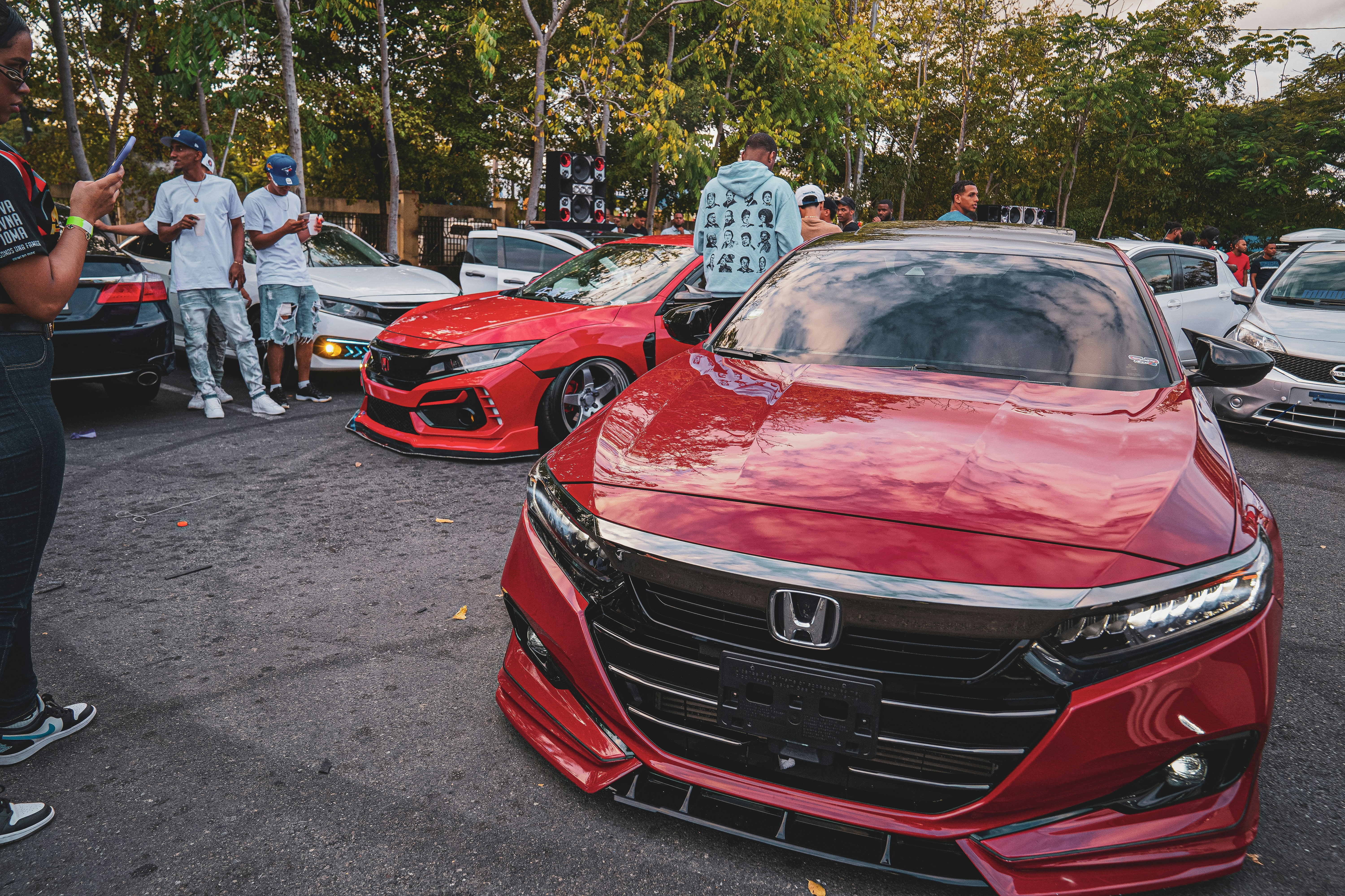 A red car parked in a parking lot next to other cars photo – Free ...