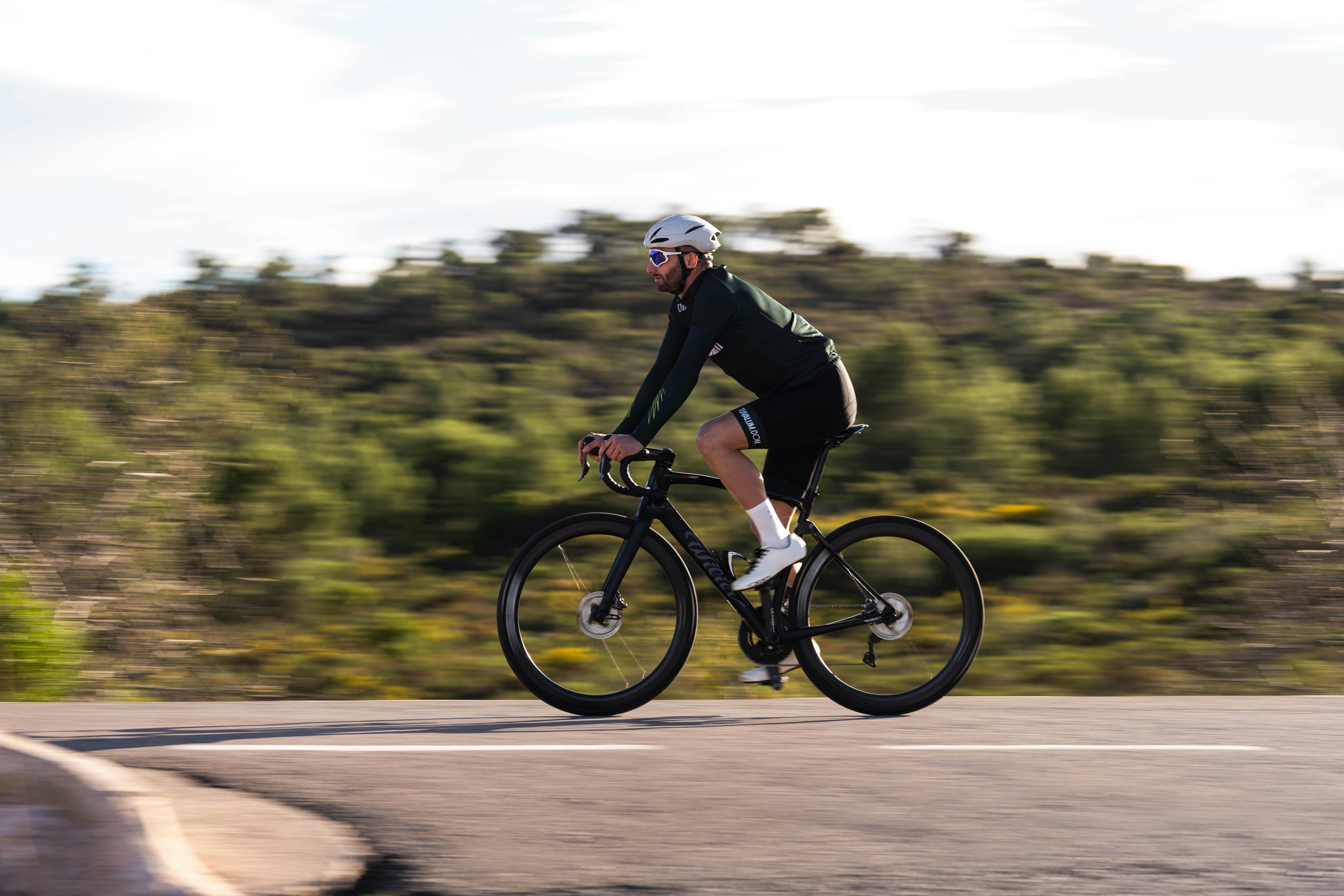 A man riding a bike down a curvy road photo – Free Bicicleta de ...