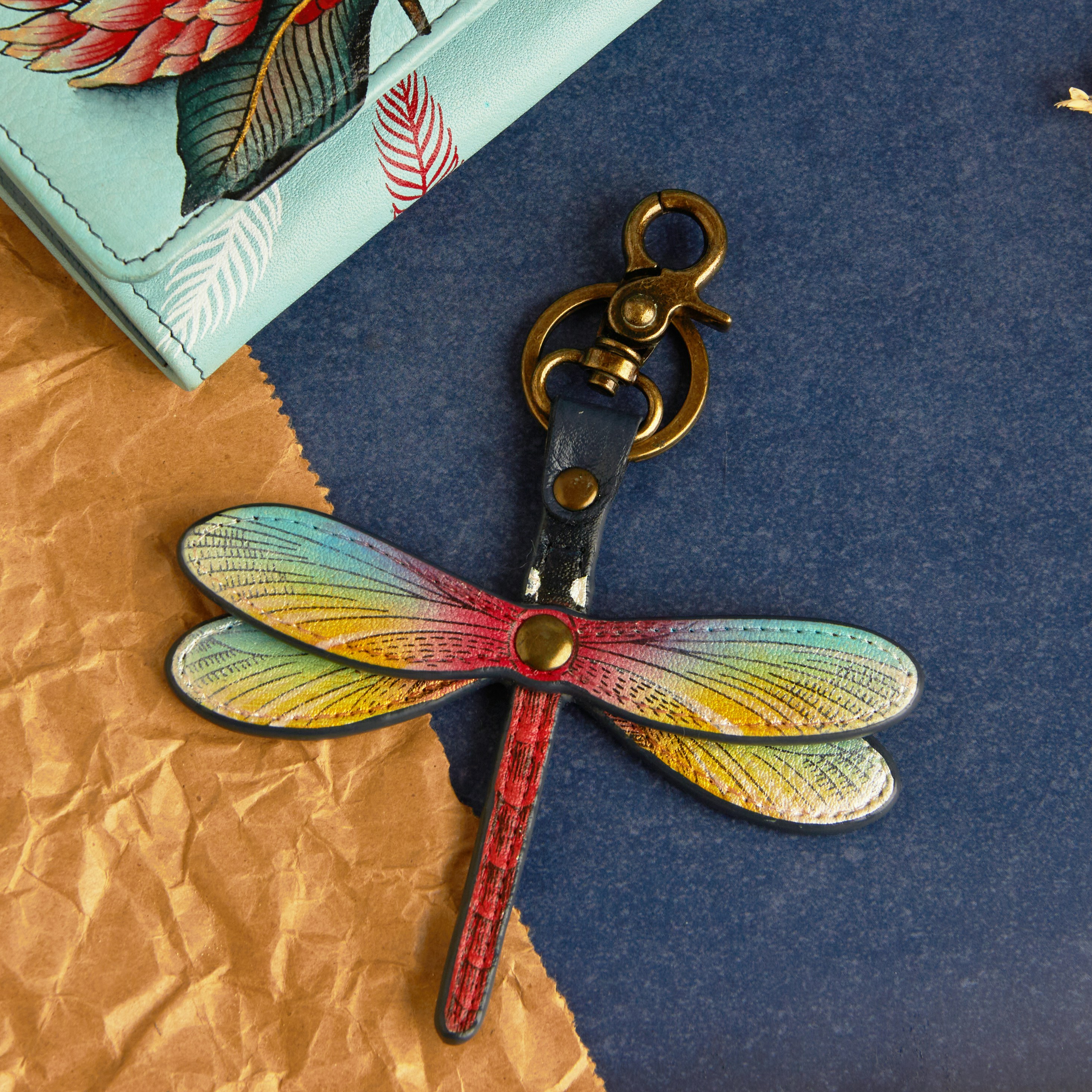 Rainbow Dragonfly Charm on a Textured Workspace