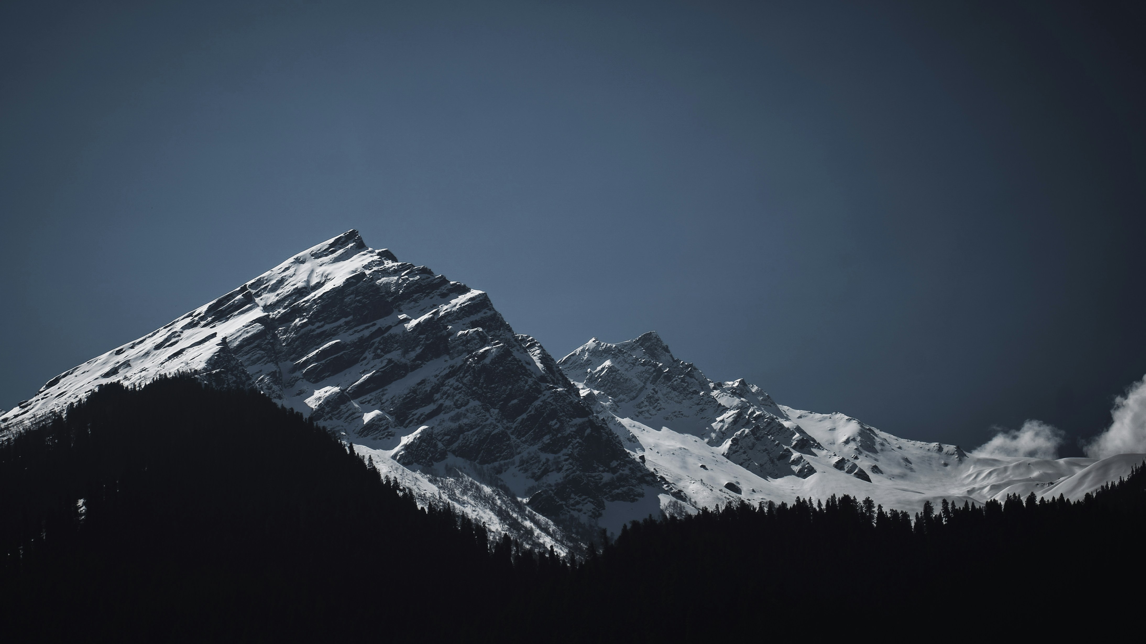 A snow covered mountain under a dark blue sky photo – Free Himachal ...