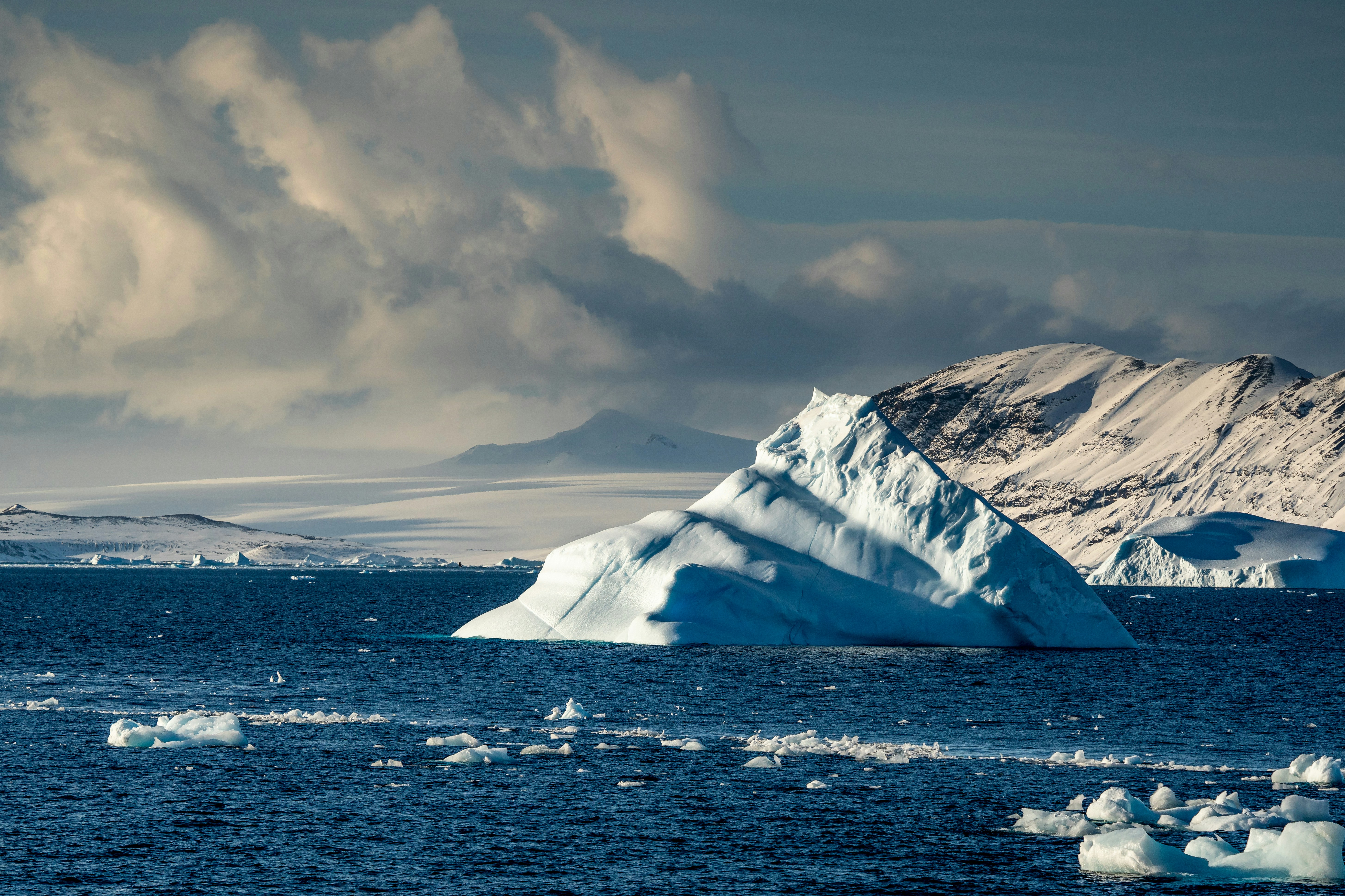 A large iceberg floating on top of a body of water photo – Free Ice ...
