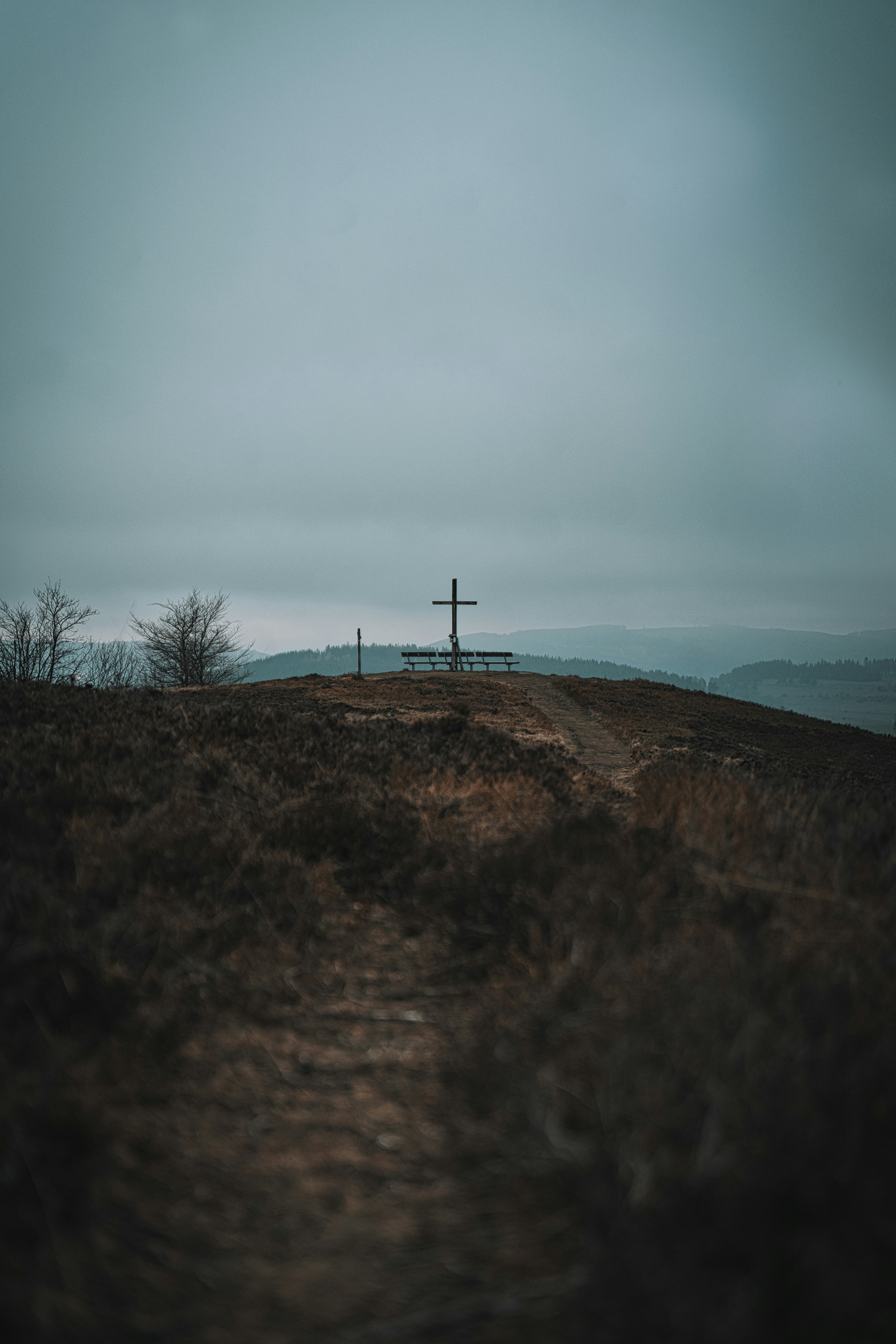 Lone Cross on a Wind-Swept Hill Under a Clouded Sky