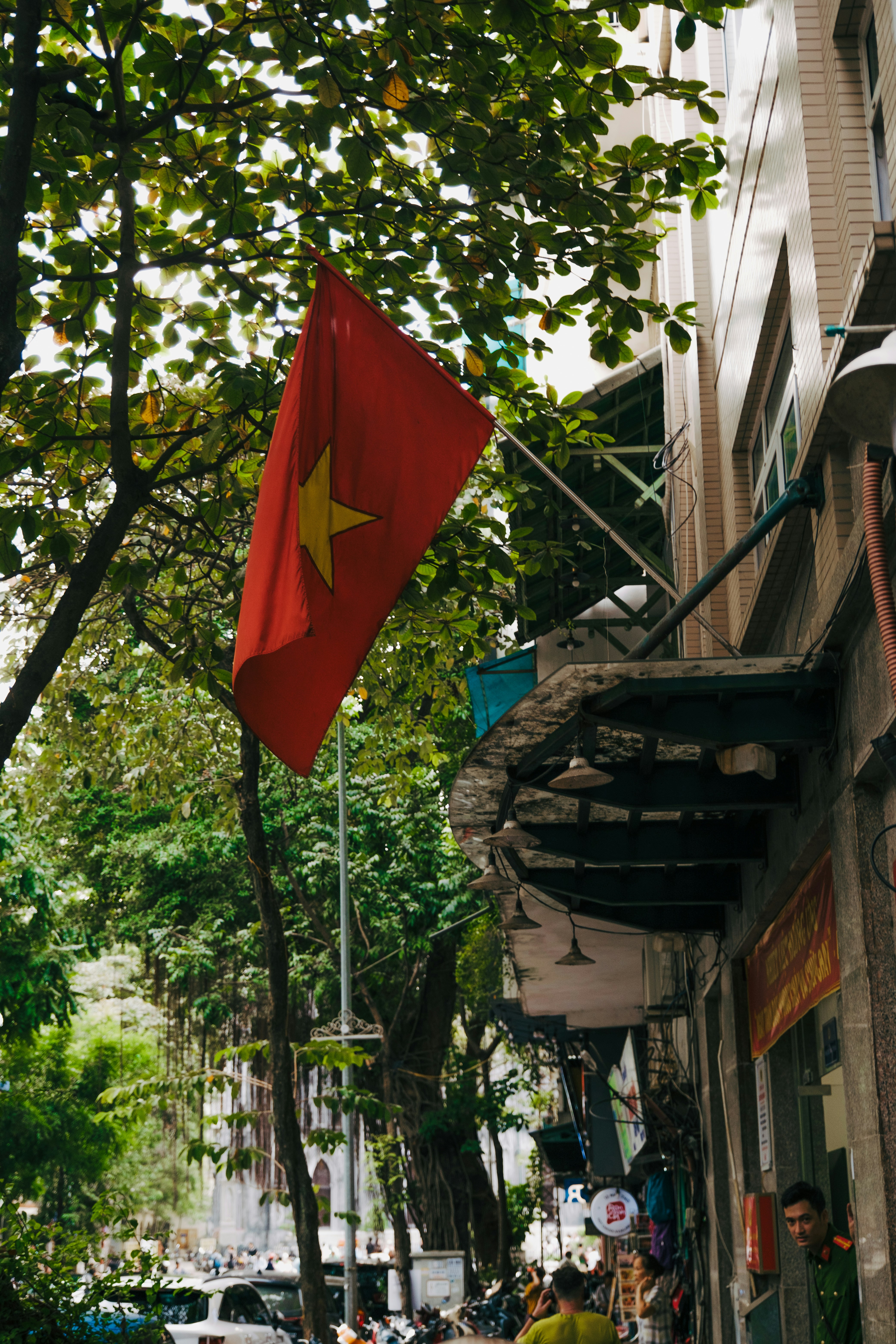 A red flag hanging from the side of a building photo – Free Flag Image ...