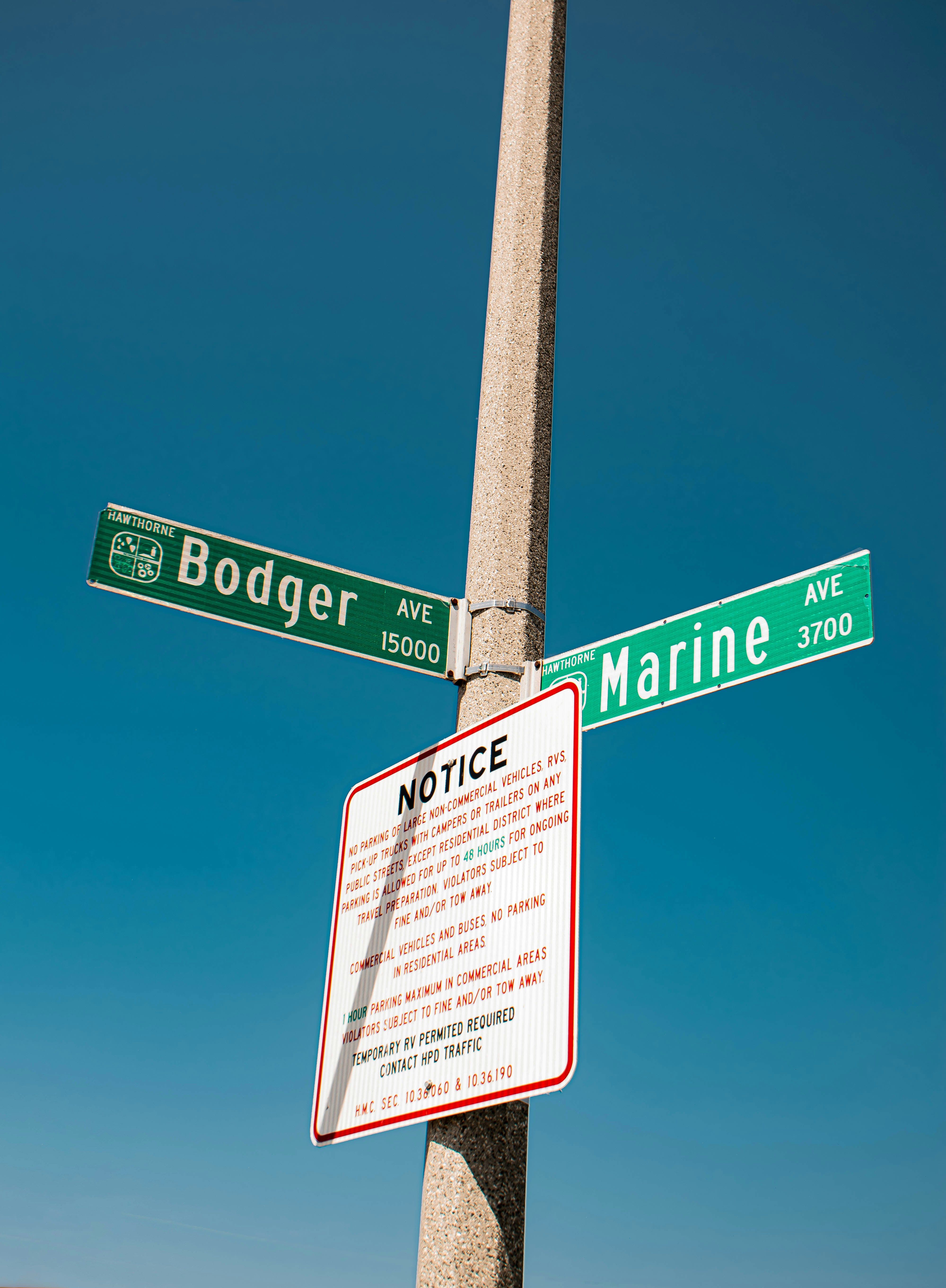 A pole with two street signs on top of it photo – Free Road signs Image ...