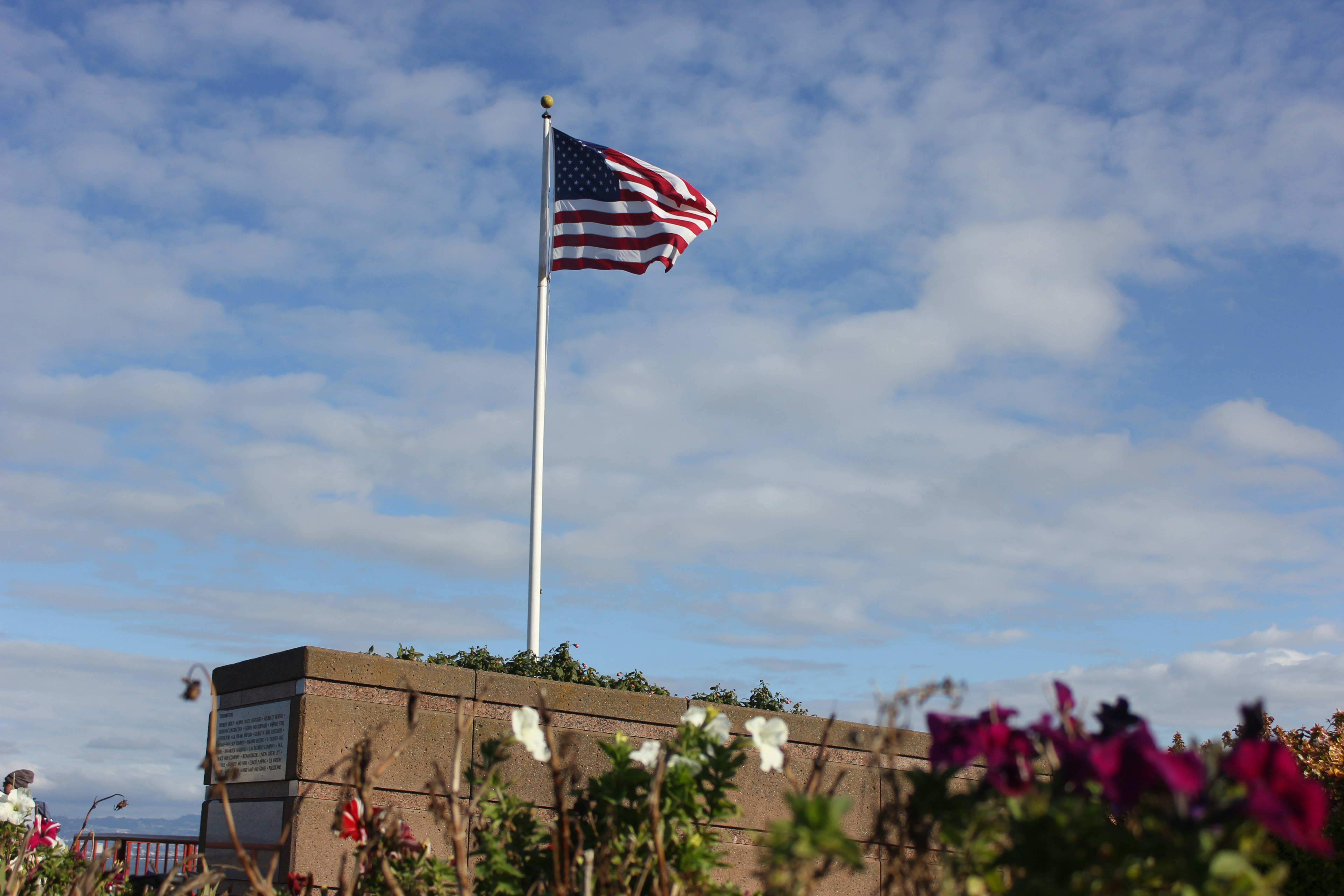 an american flag is flying over a memorial