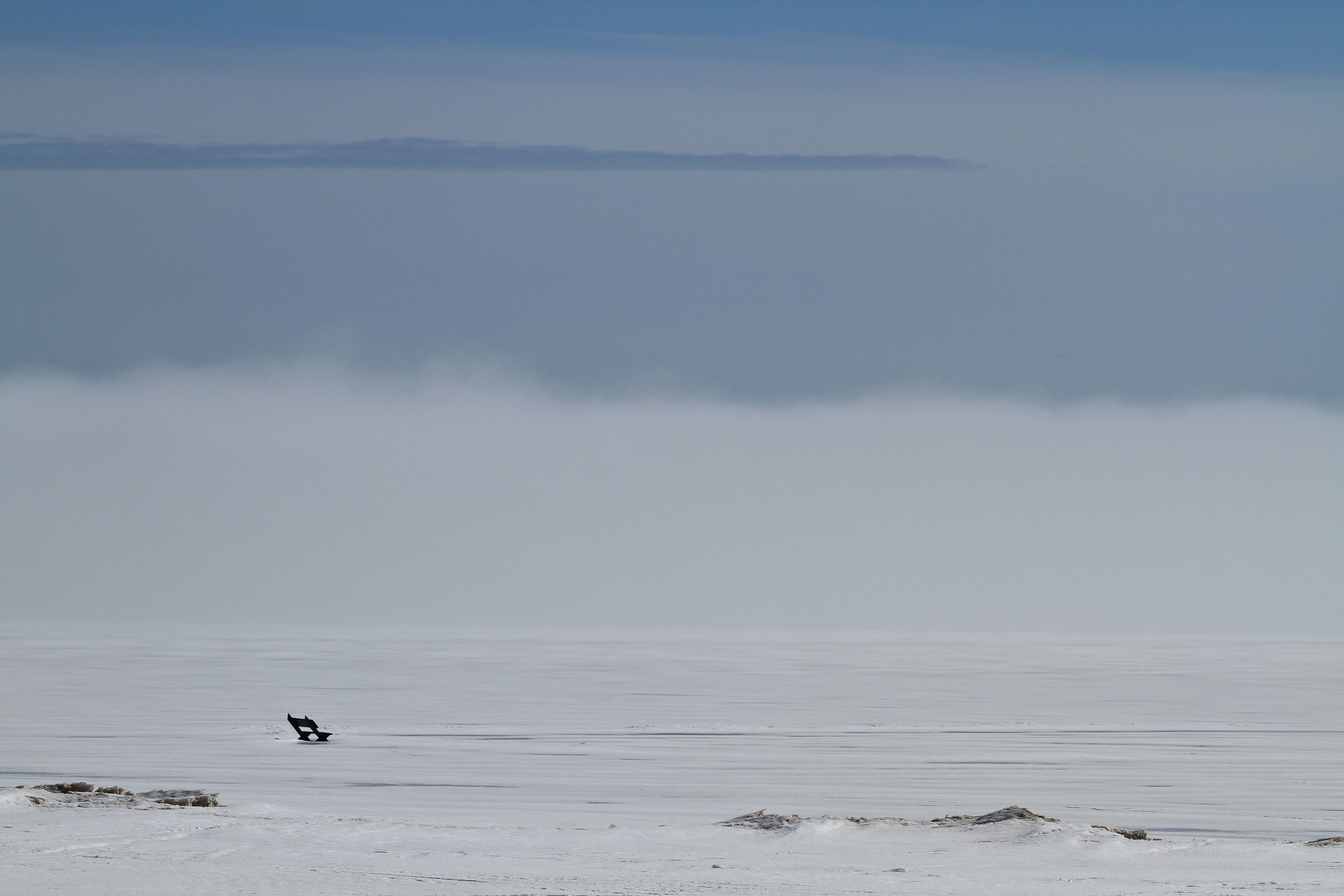 Lone Silhouette on a Wind-Swept Snow Plain Beneath a Layered Sky