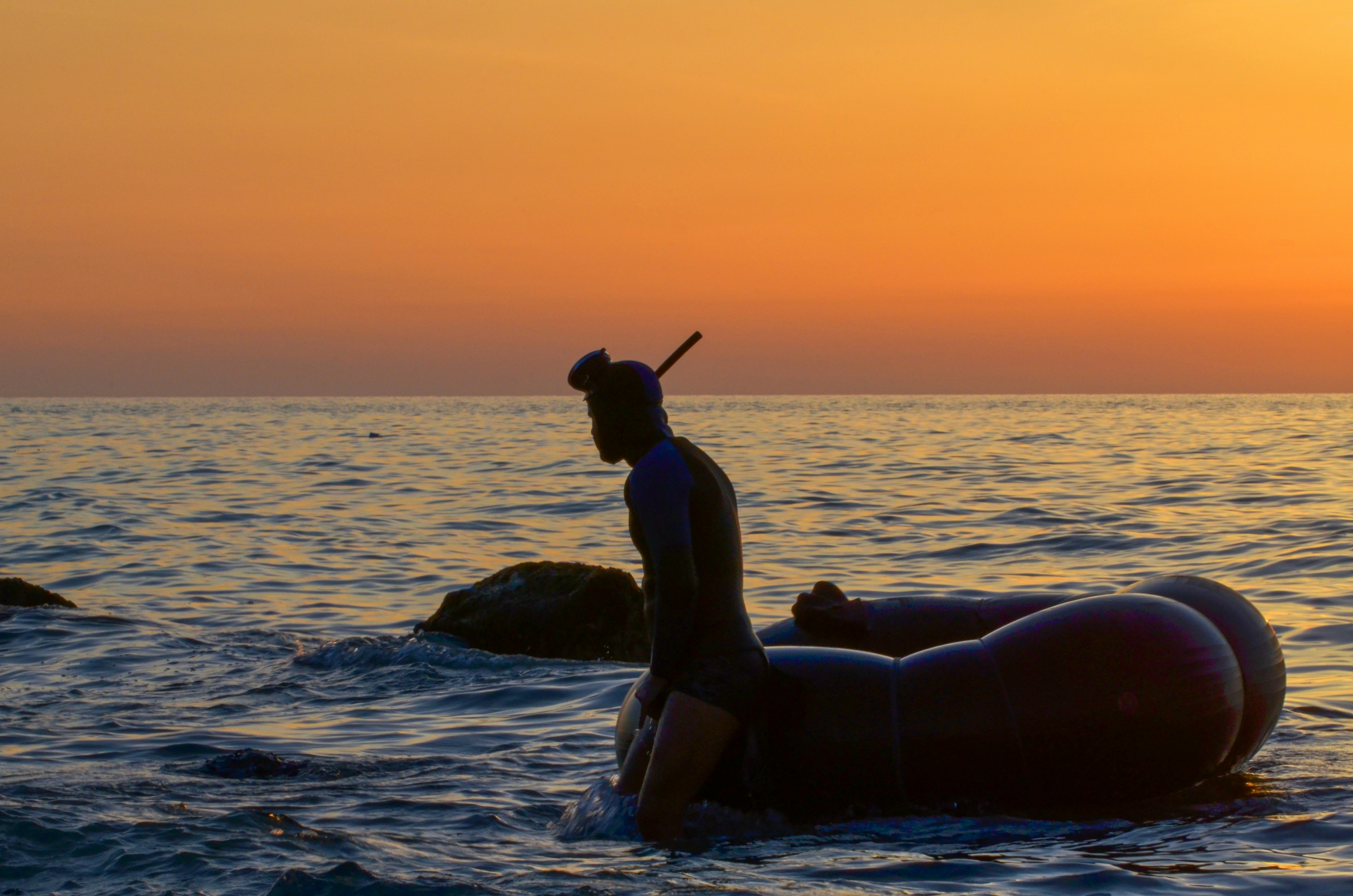 Sunset Silhouette: Snorkeler Adrift on a Golden Sea