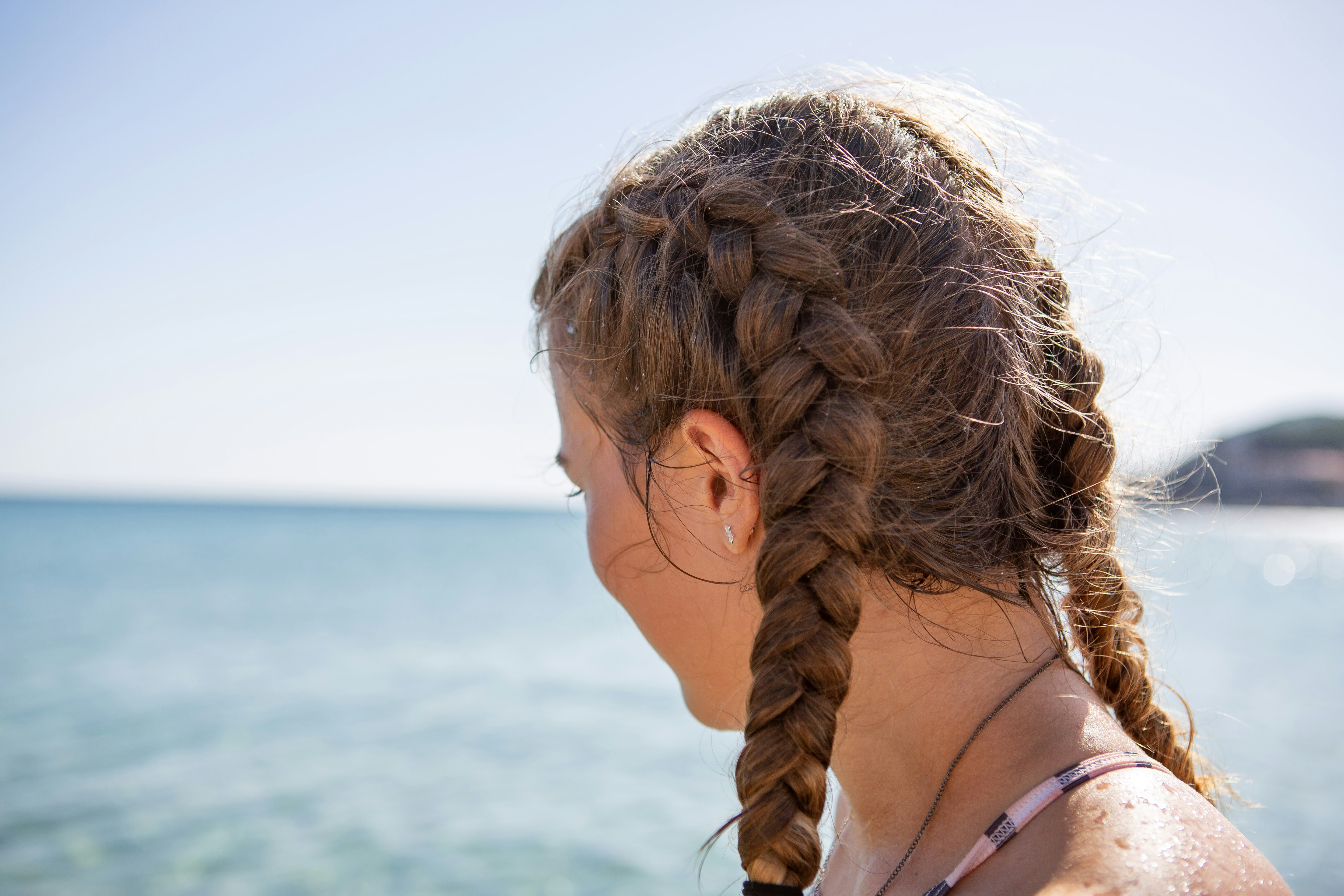 Elba is like our second home; we love to come back, live there and feel so good after our time there. It's wonderful and most of time we spend at the beach. | a girl with a braid standing on the beach