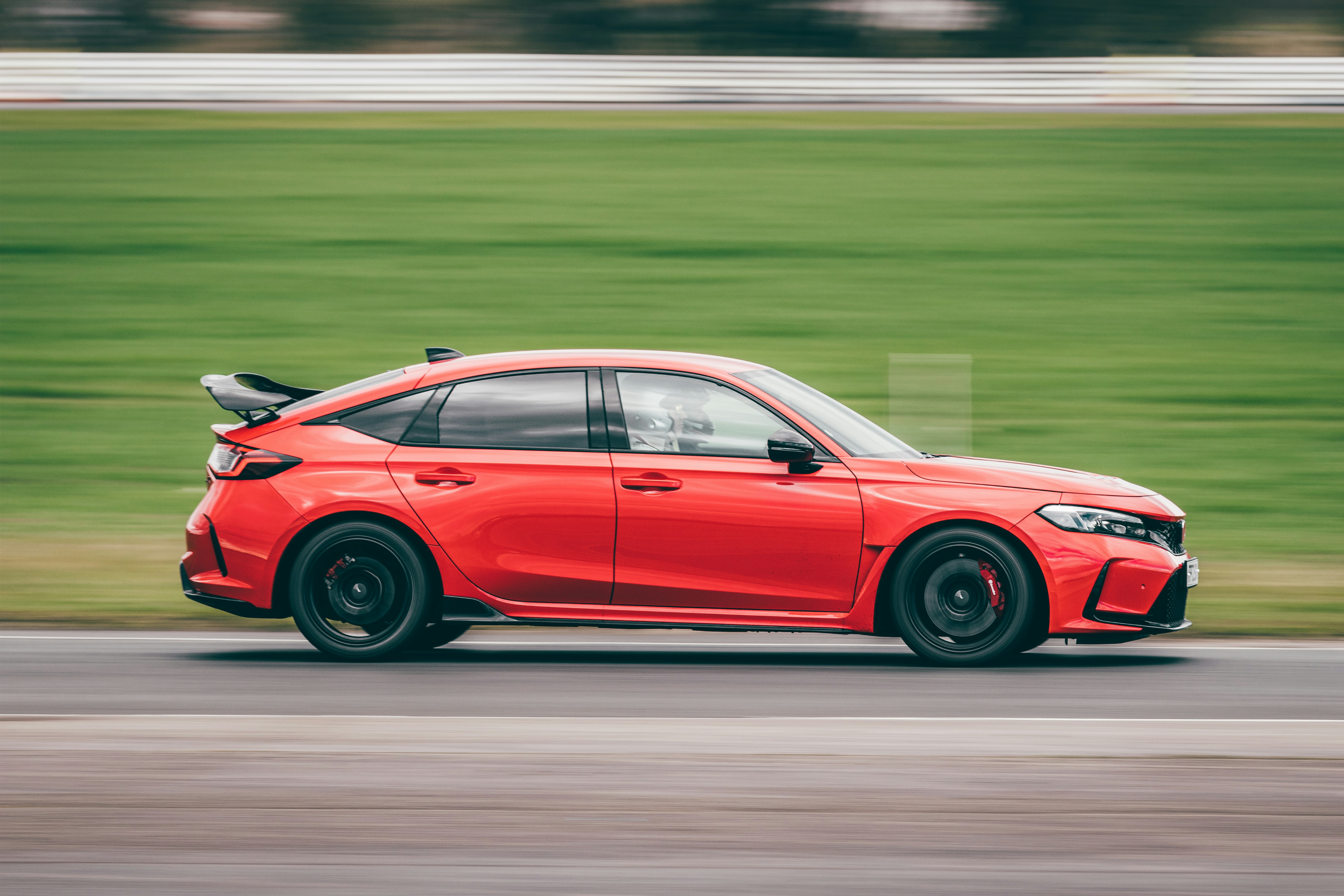 Scarlet Sprint: Red Sedan Carves Through Motion on a Blur-Streak Track