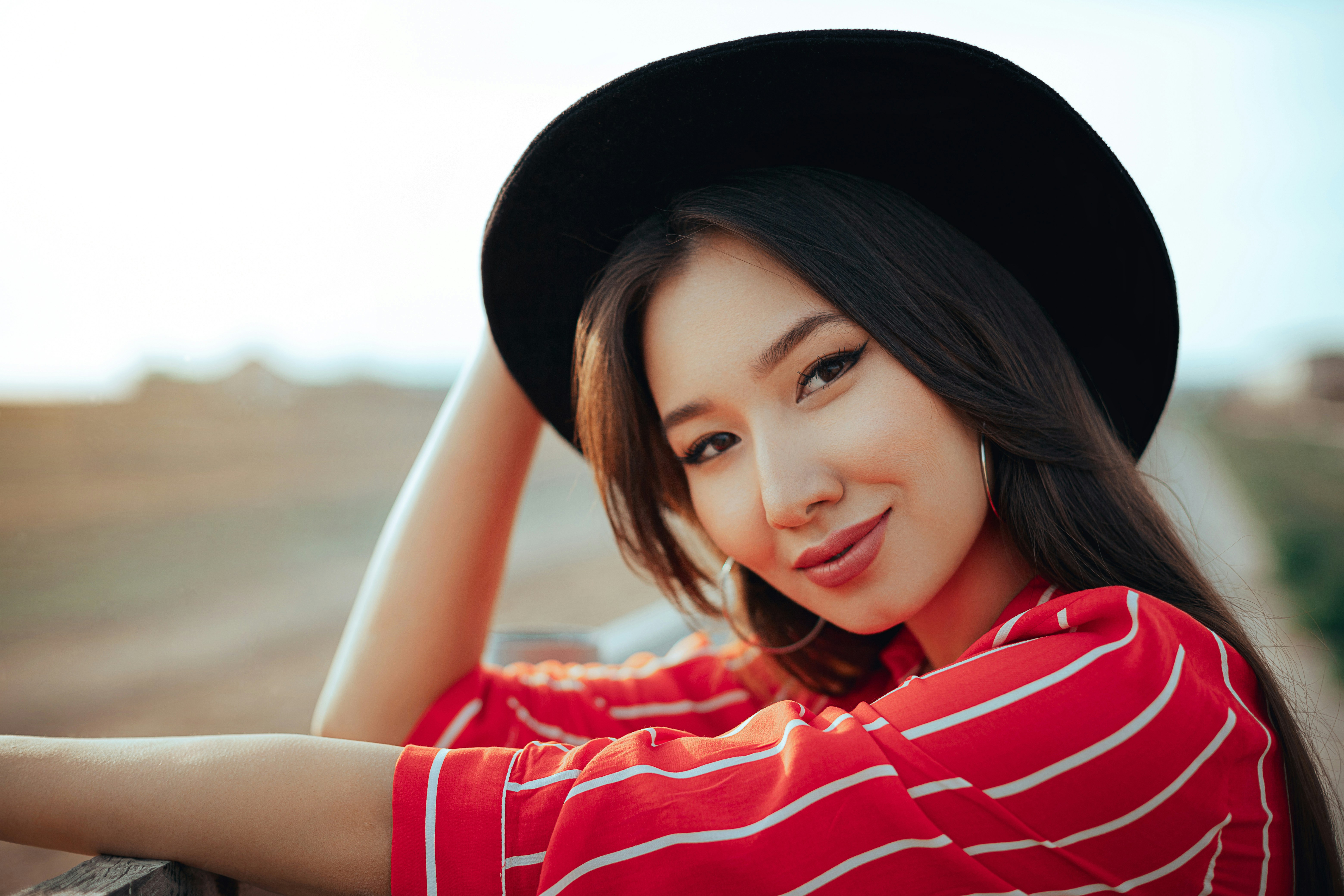 A woman wearing a hat leaning on a rail photo – Free Portrait Image on ...