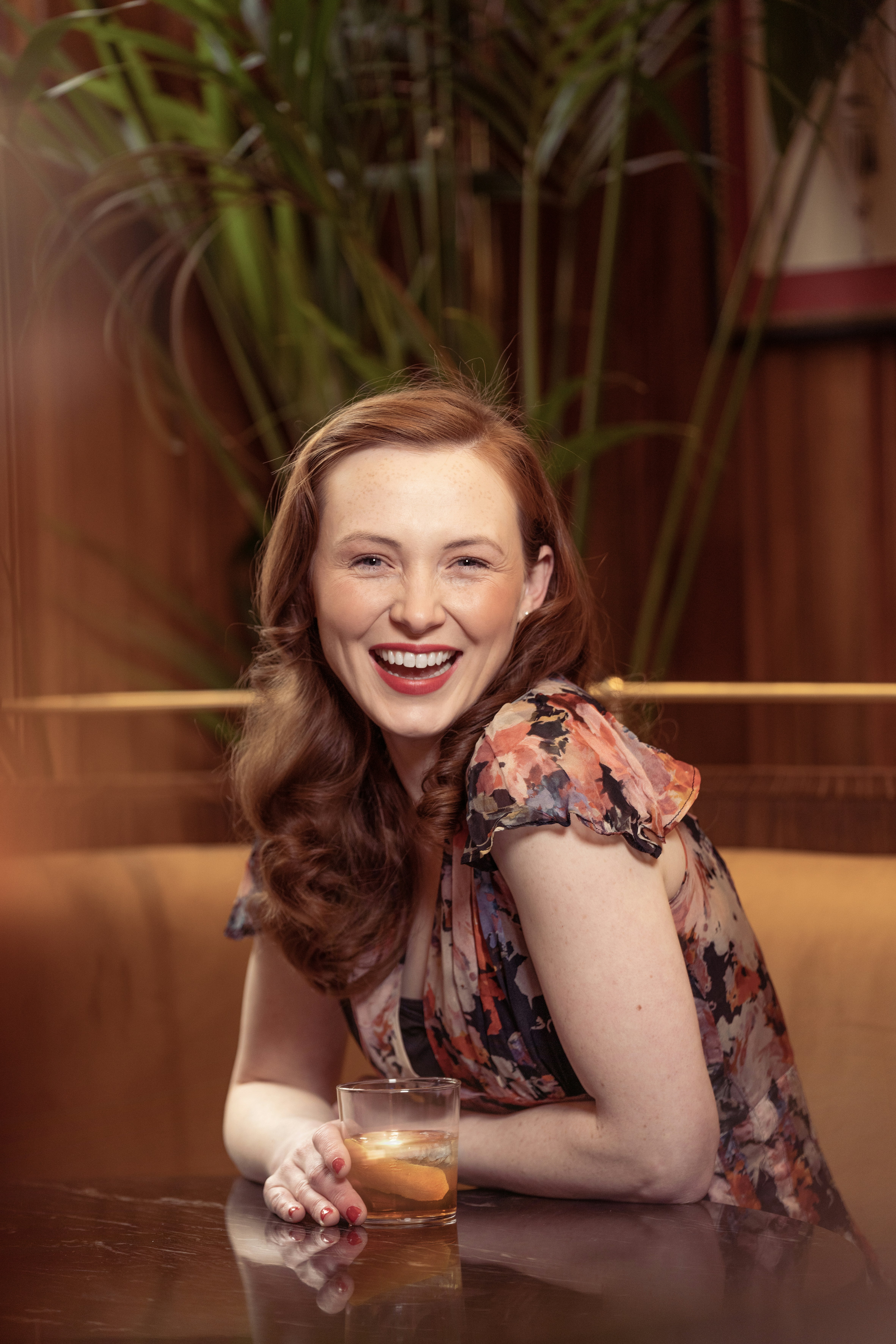 Amber Glow at the Bar: Portrait of a Red-Haired Smile