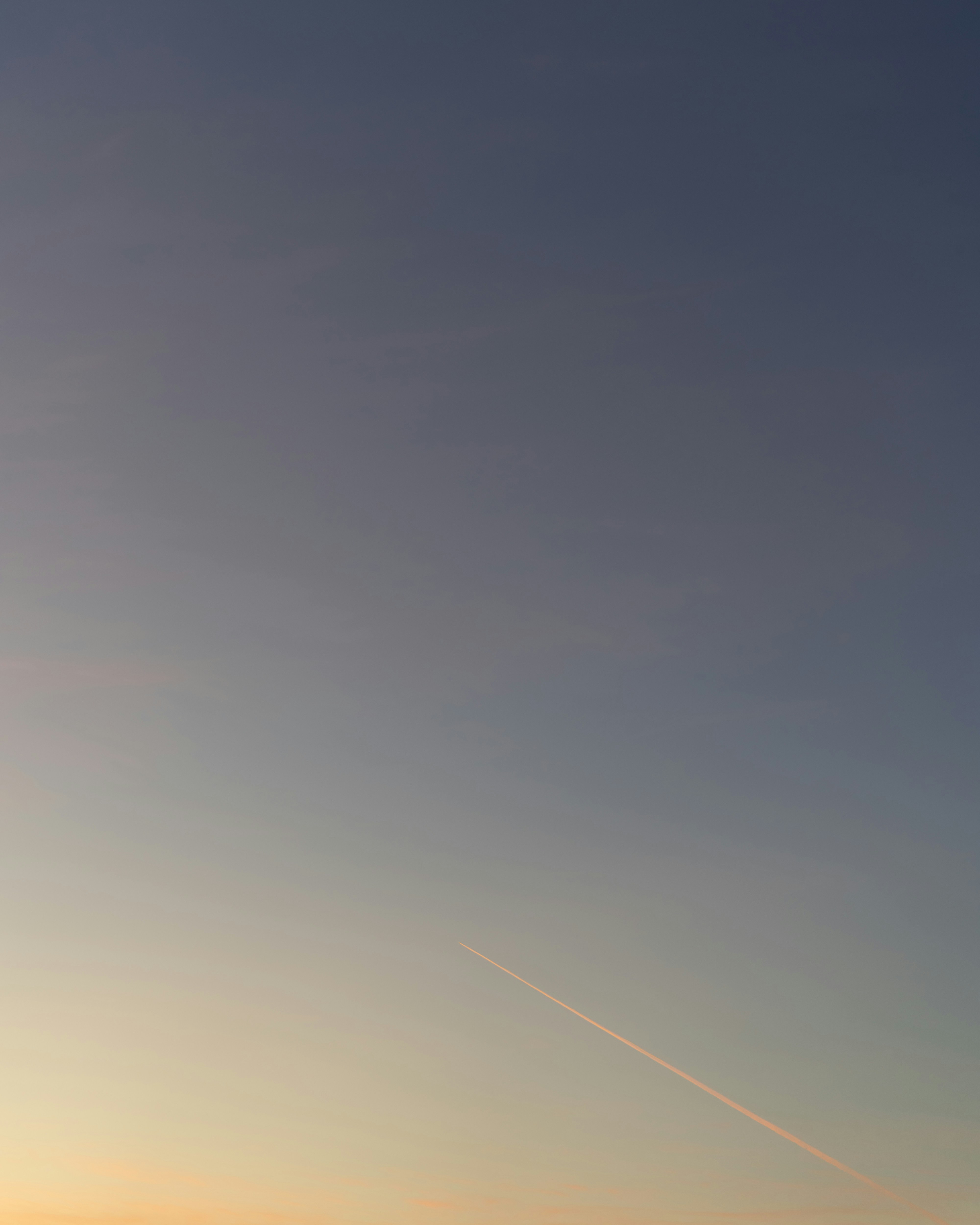 Jet Trail | a plane flying in the sky at sunset