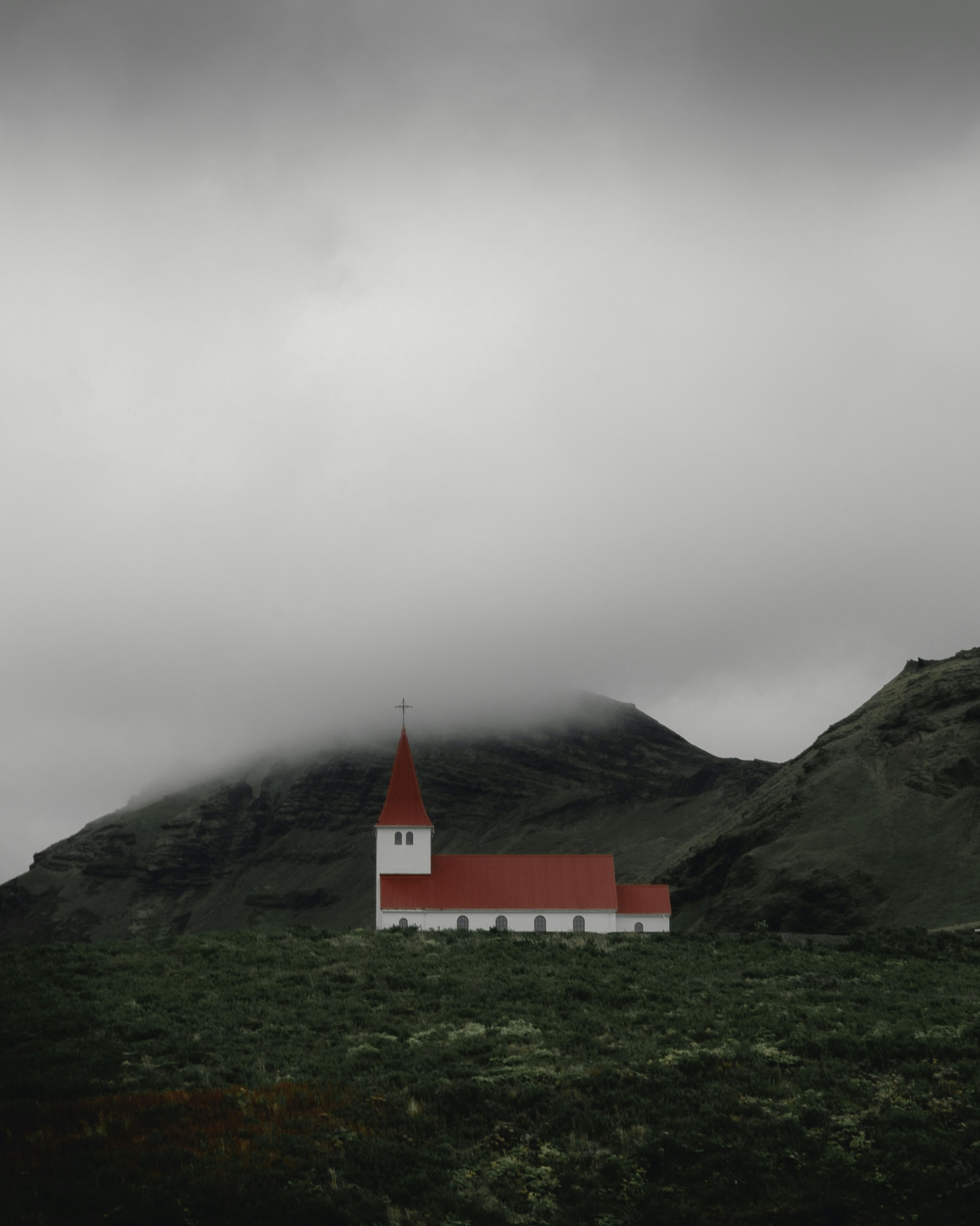 A red and white church on a hill under a cloudy sky photo – Free ...