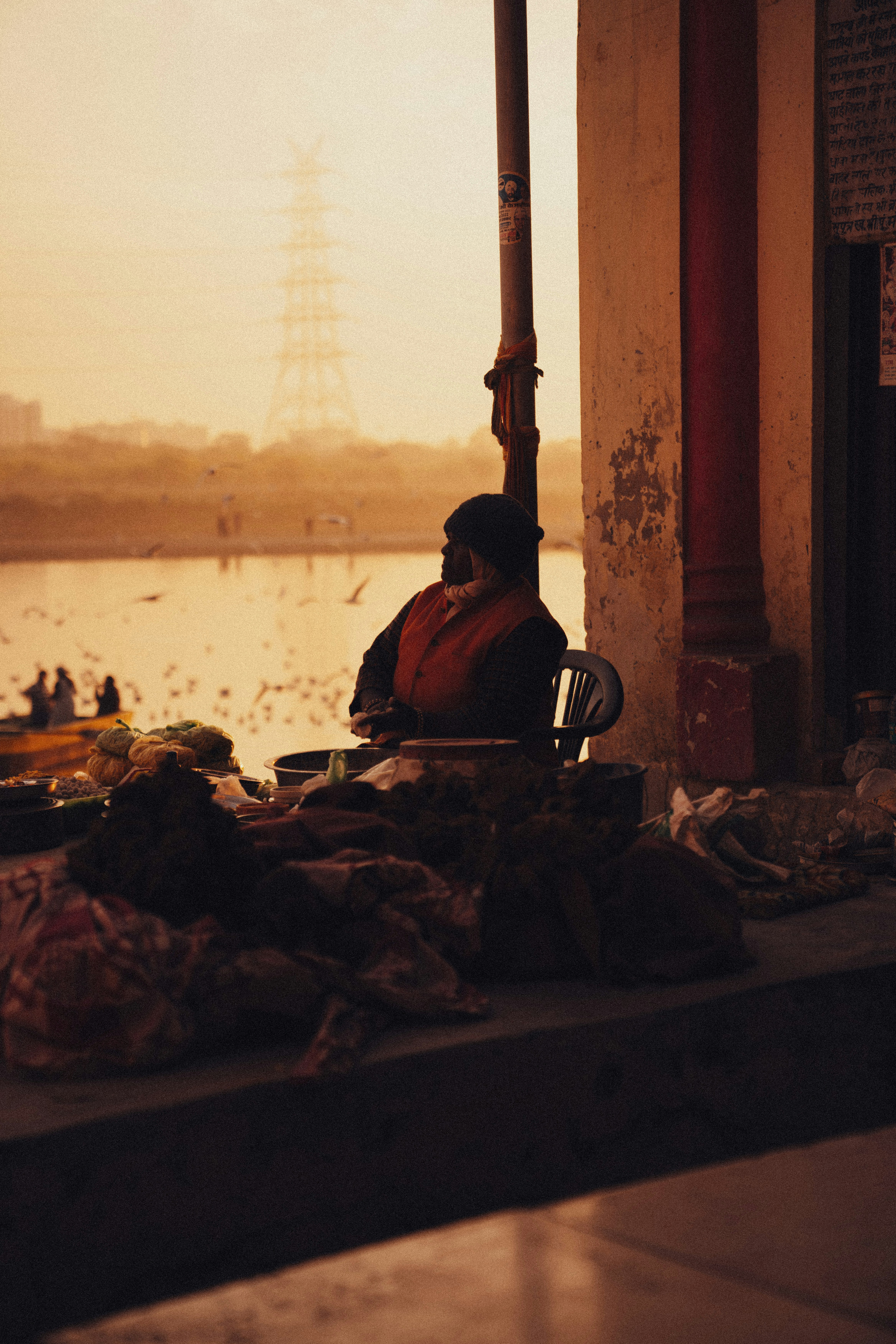 a woman sitting on a bench next to a body of water