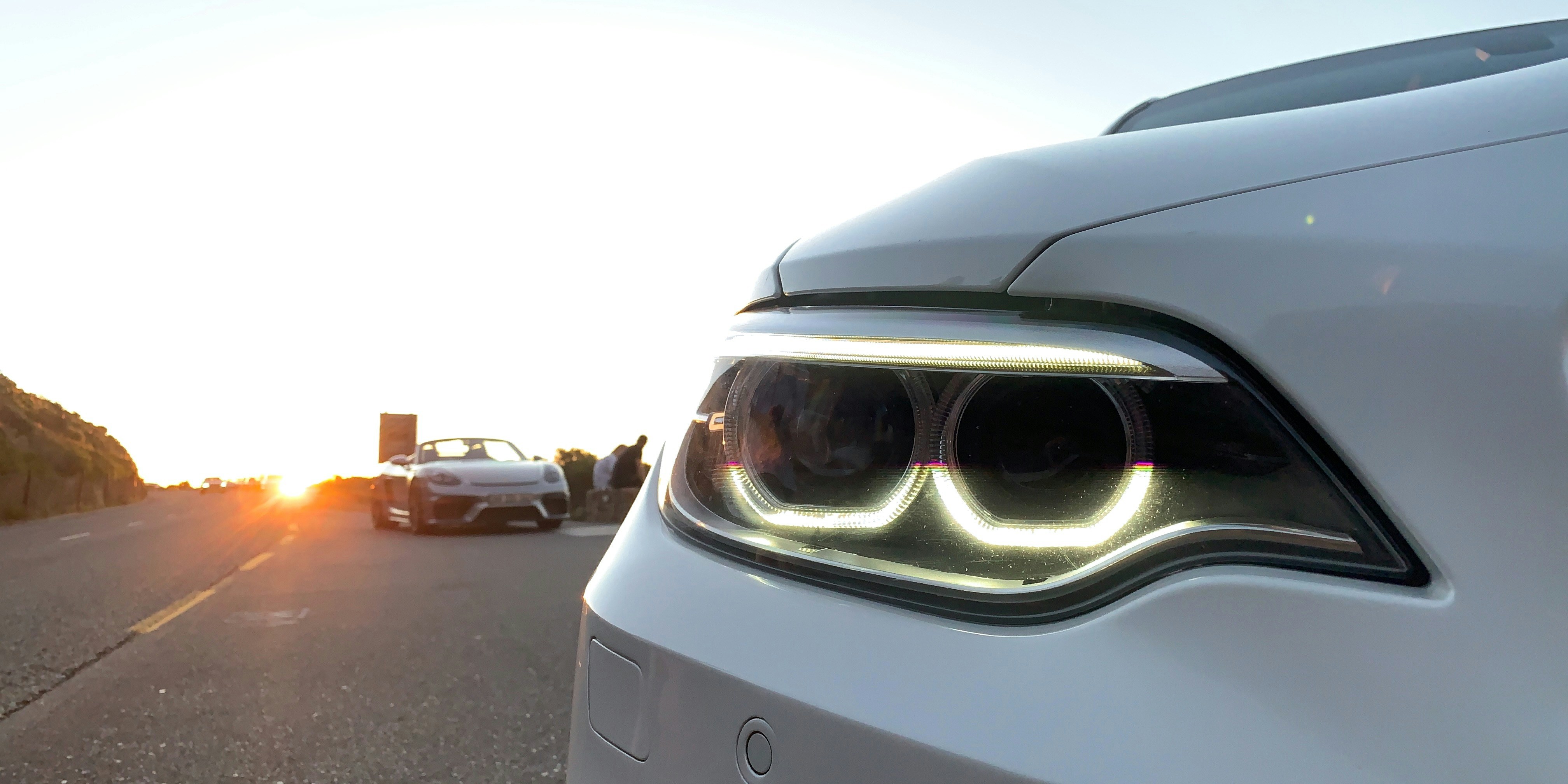 Haloed Focus: Sunset close-up on a silver sports sedan's LED ring