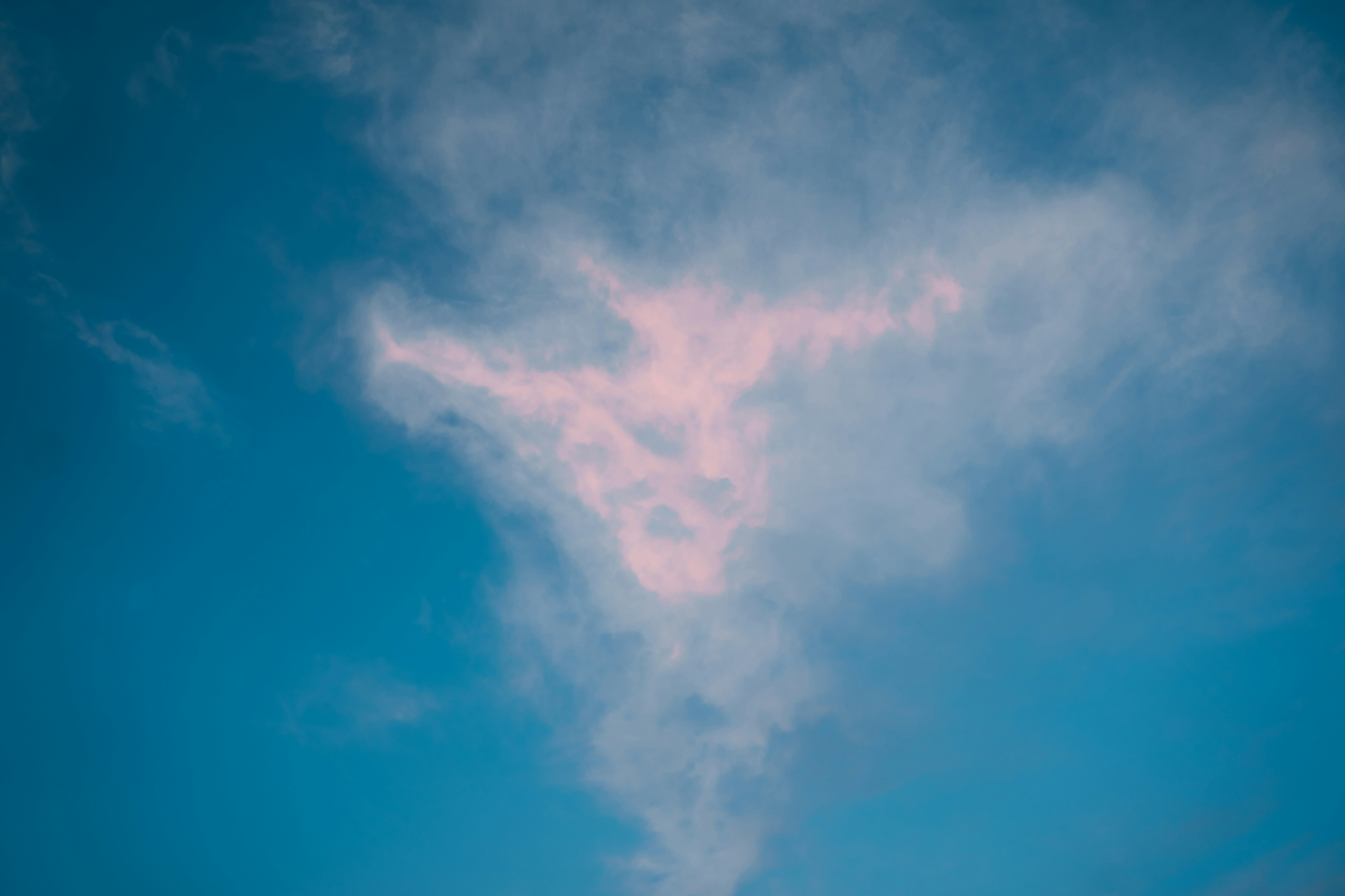 Top-Center Rosy Cloud Drifts Across a Cerulean Sky