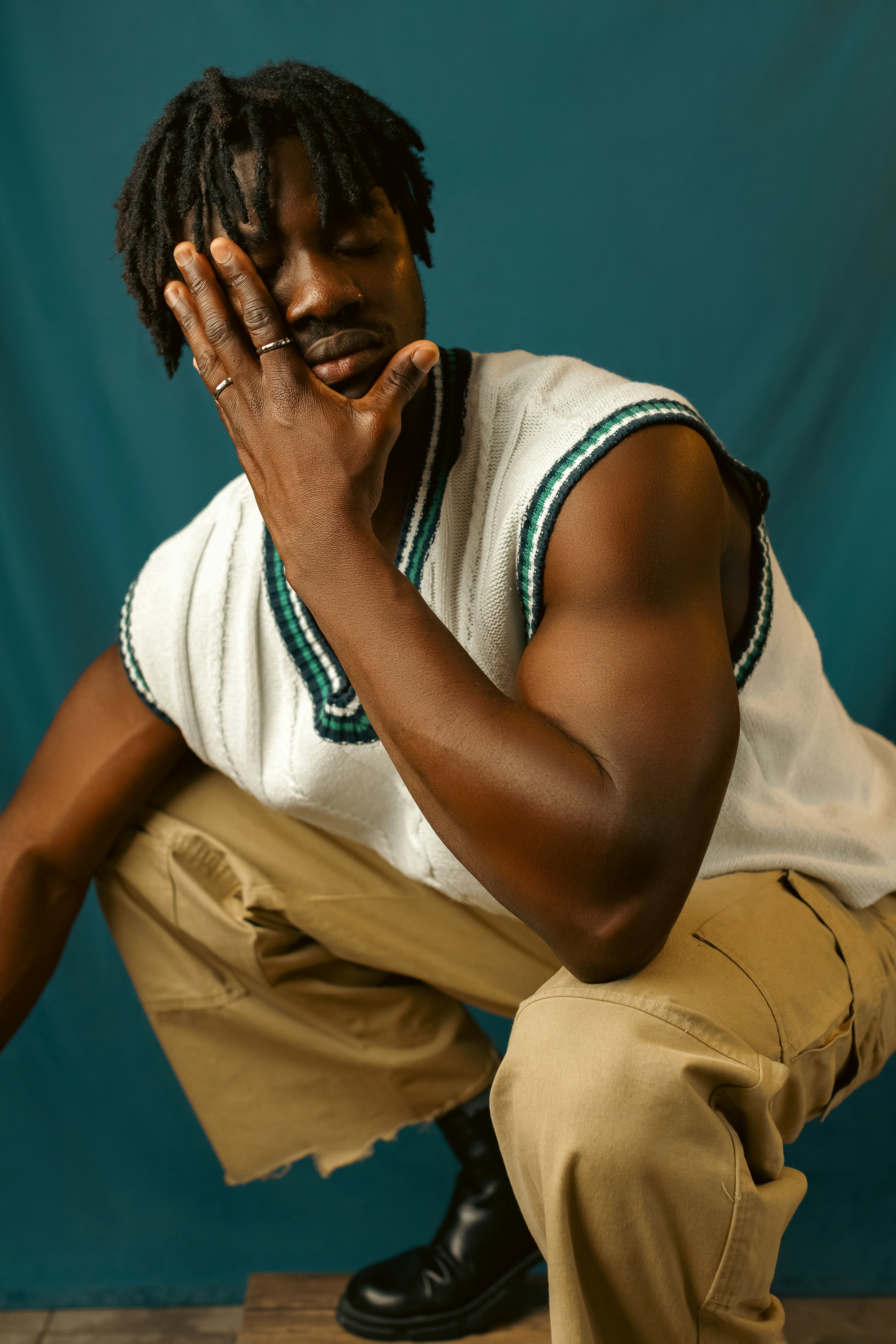 A man with dreadlocks sitting on a wooden floor photo – Free Creative ...