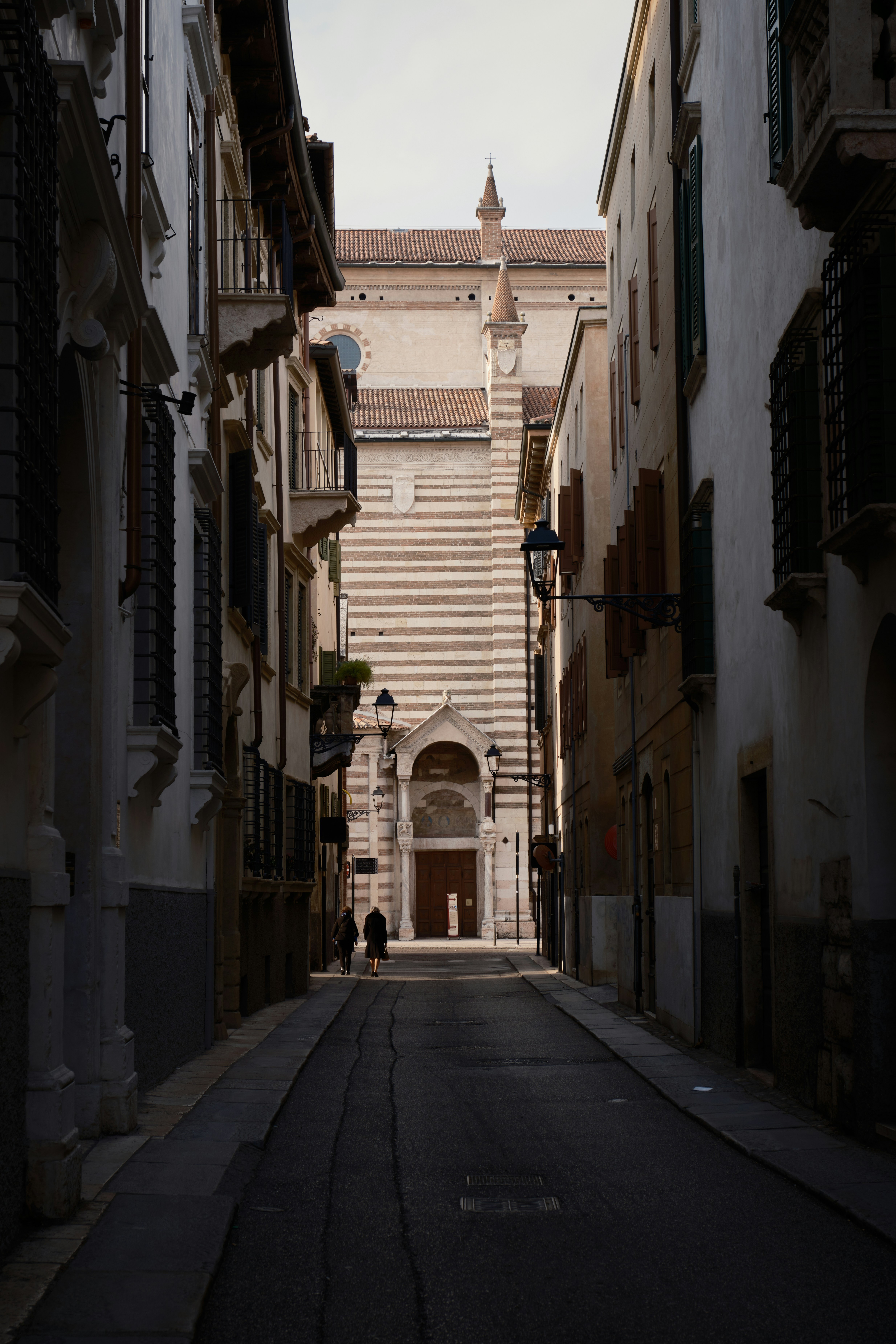 a narrow street with a tall building in the background