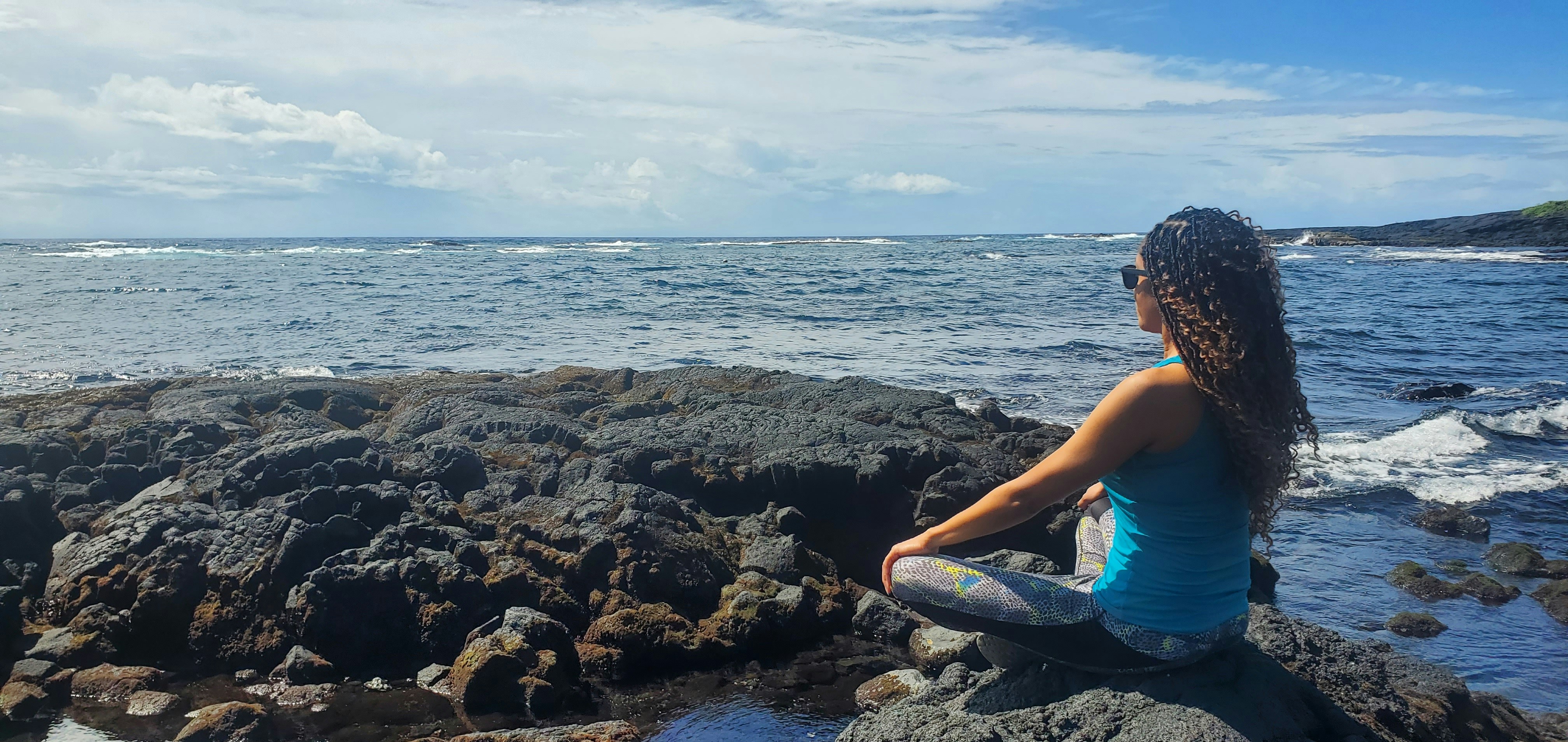 Blue Tank, Quiet Horizon: Contemplation on Rugged Seaside Rocks