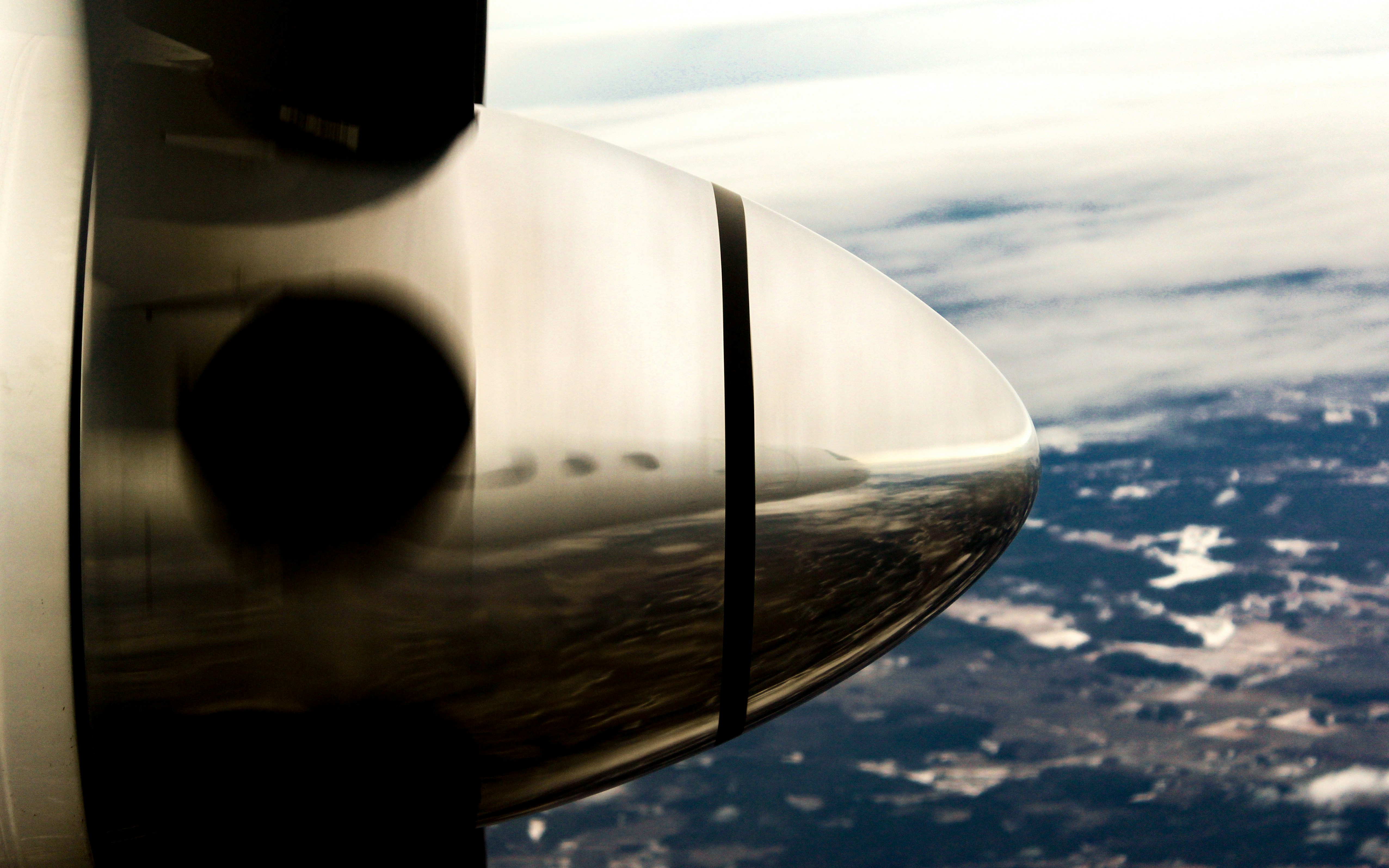 Aerial propeller hub reflections somewhere over the Sweden | a view of the wing of an airplane