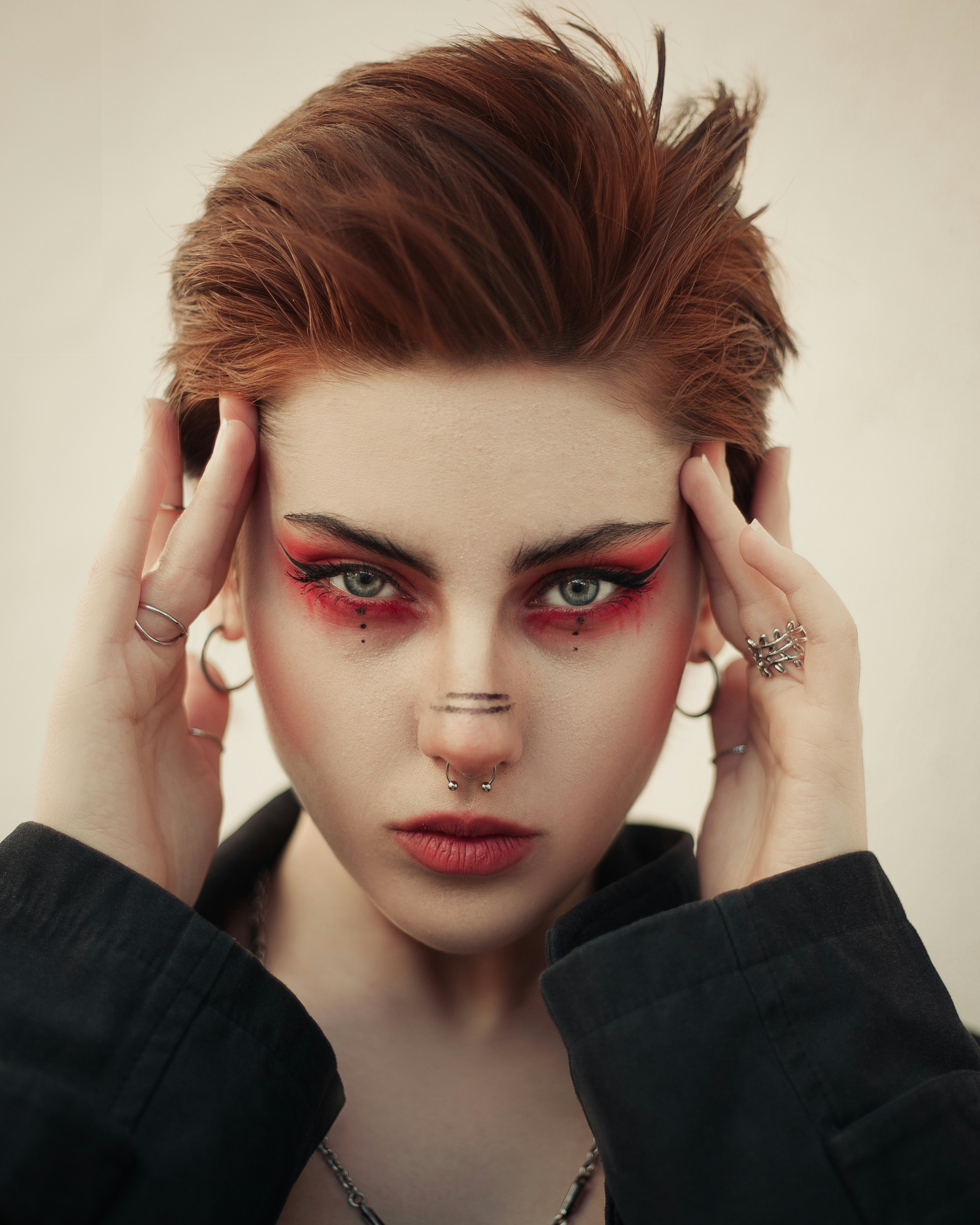 A woman with red makeup and piercings on her face photo – Free Face ...