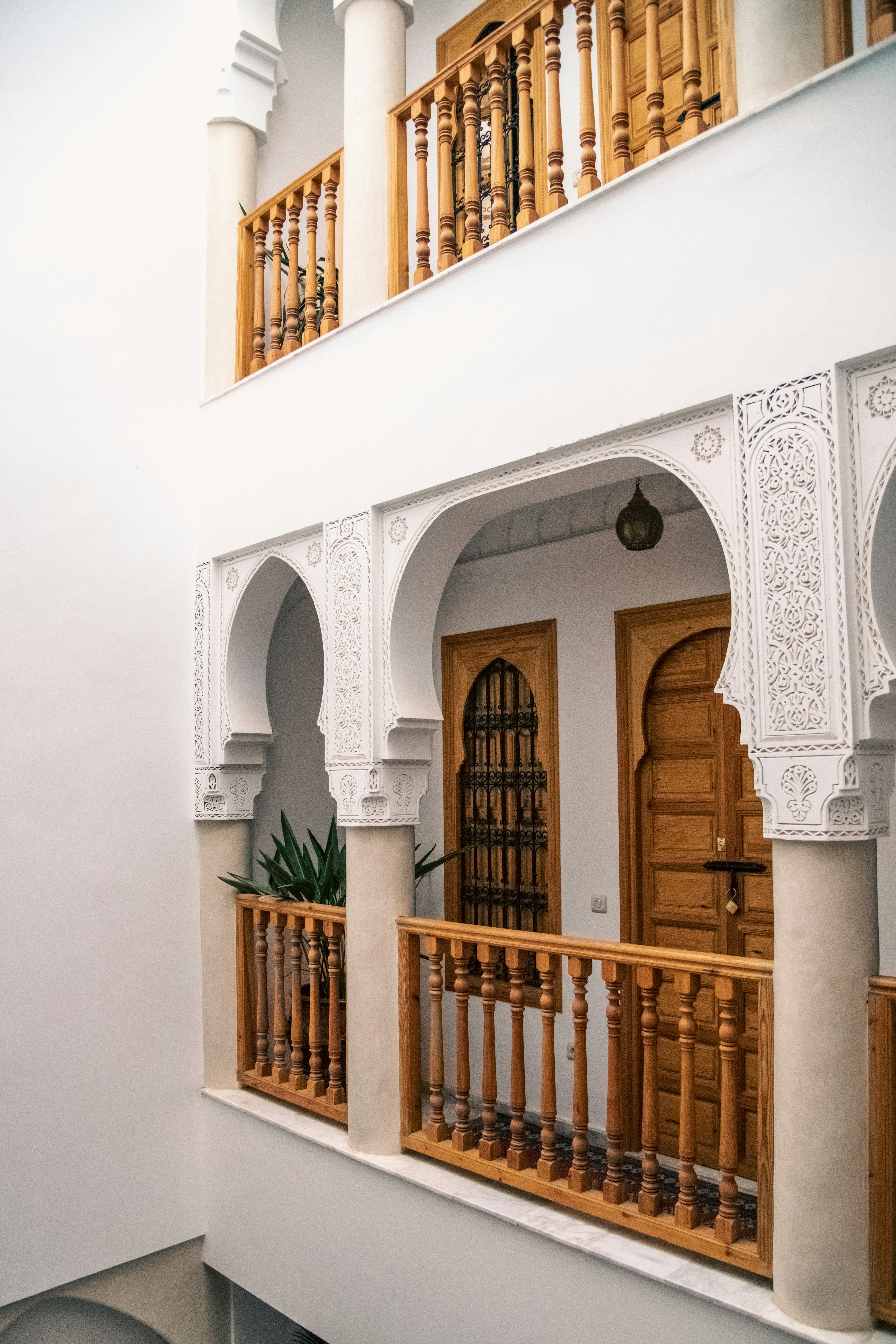 Archways in Warm Light: A White Courtyard with Carved Plaster and Woodwork
