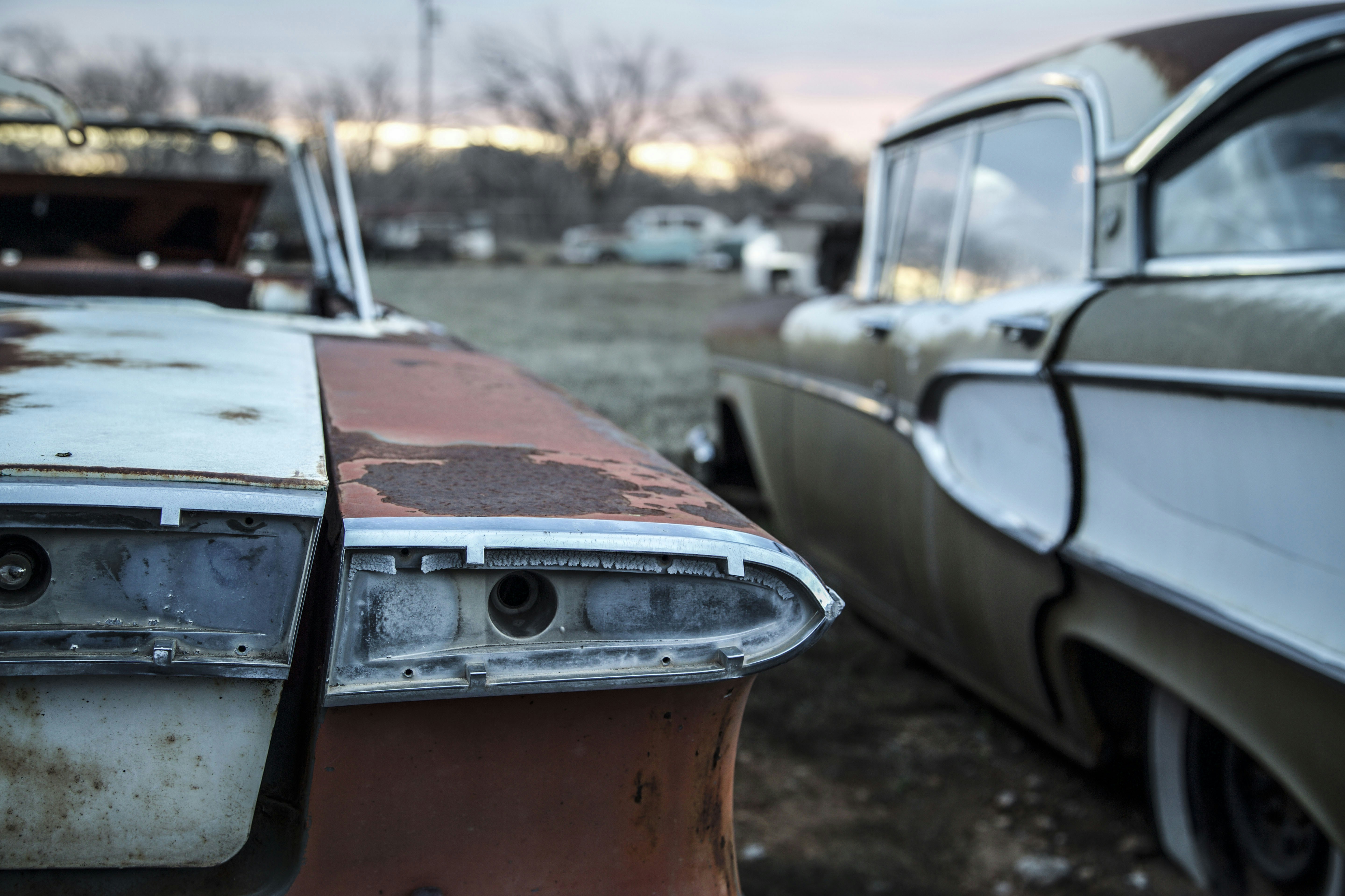 A rusted out car and a rusted out car in a field photo – Free Vehicle ...
