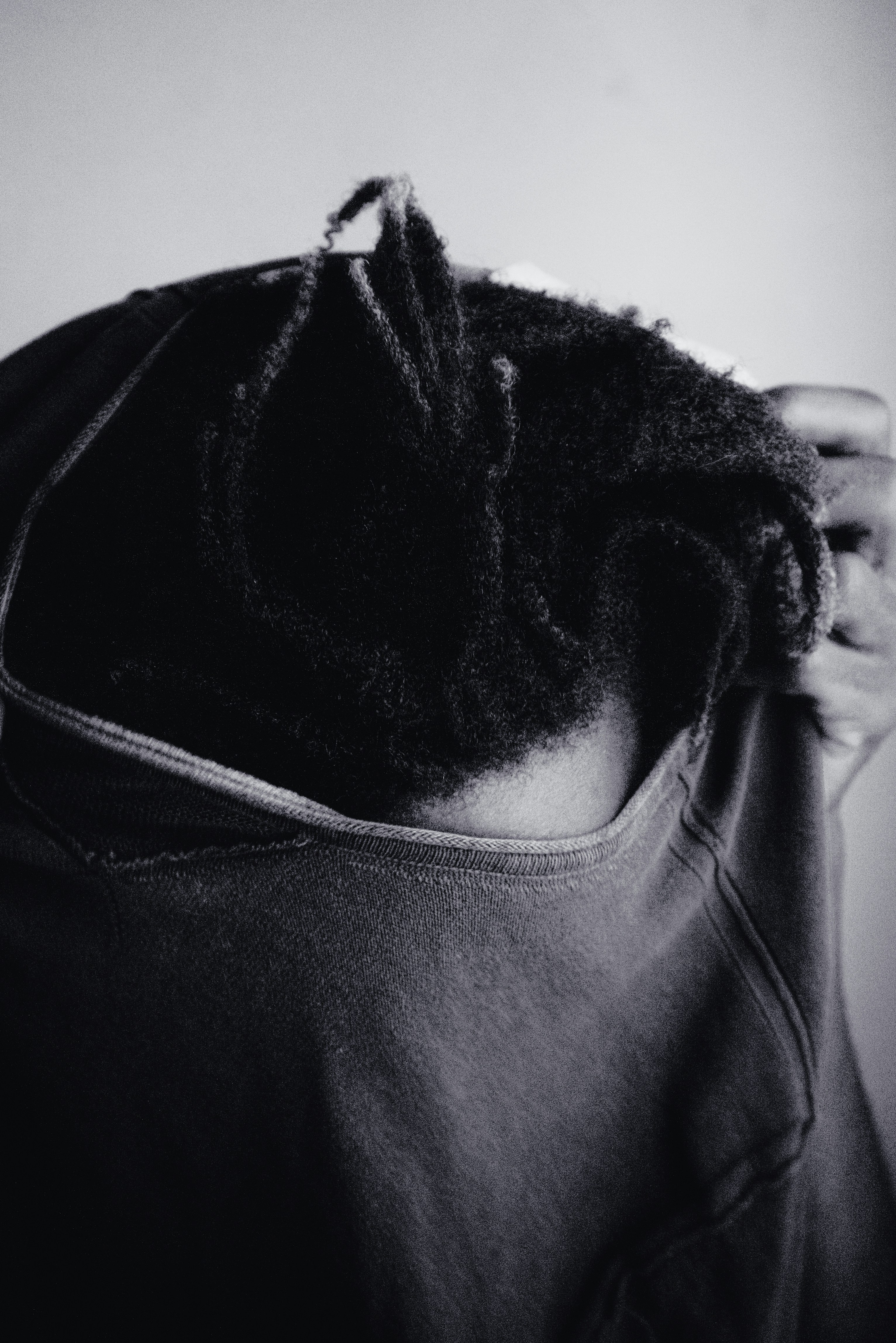 Monochrome Crown: close-up of textured dreadlocks under a hoodie