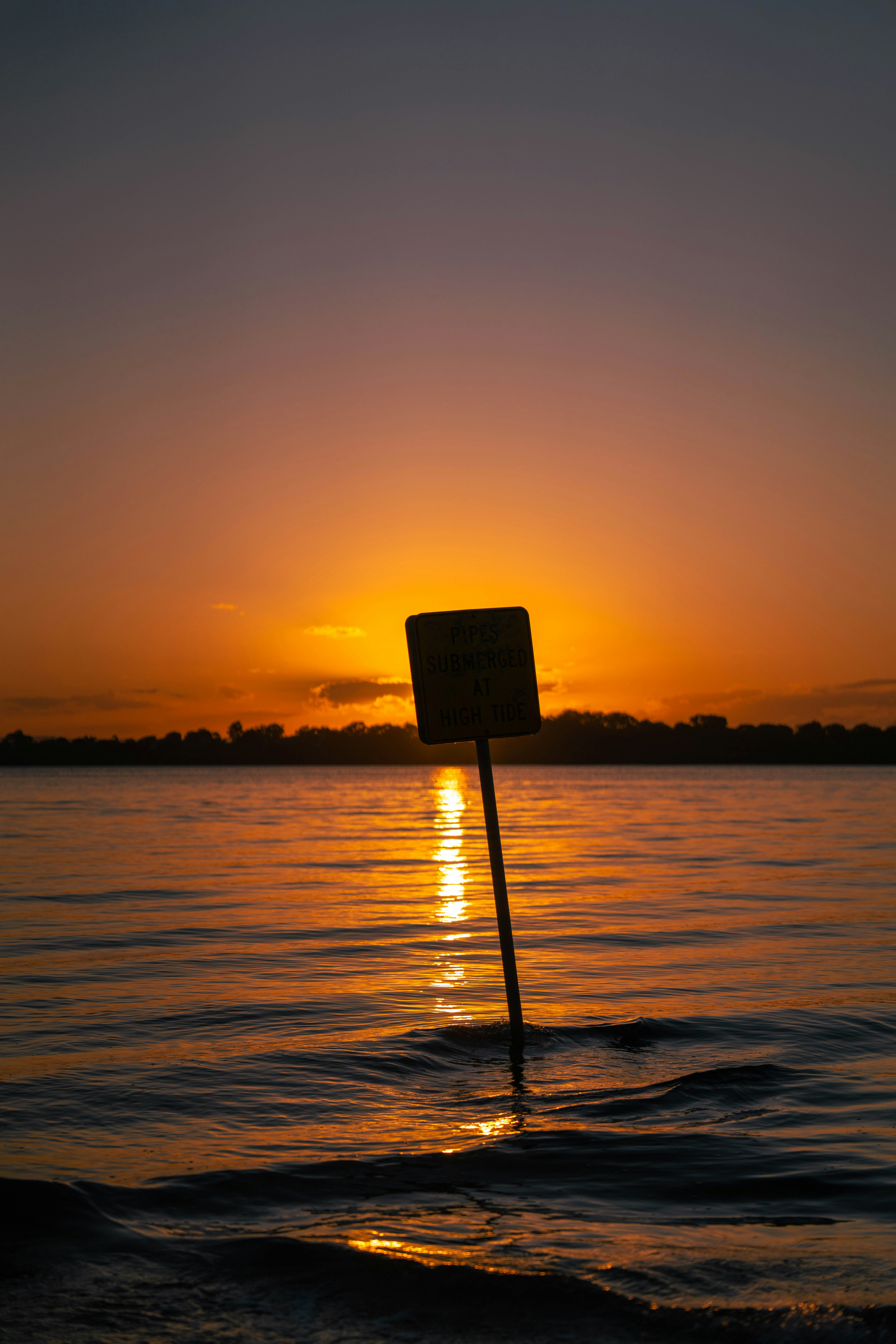 Sunset Pole: Silhouetted Sign Against a Fiery Horizon