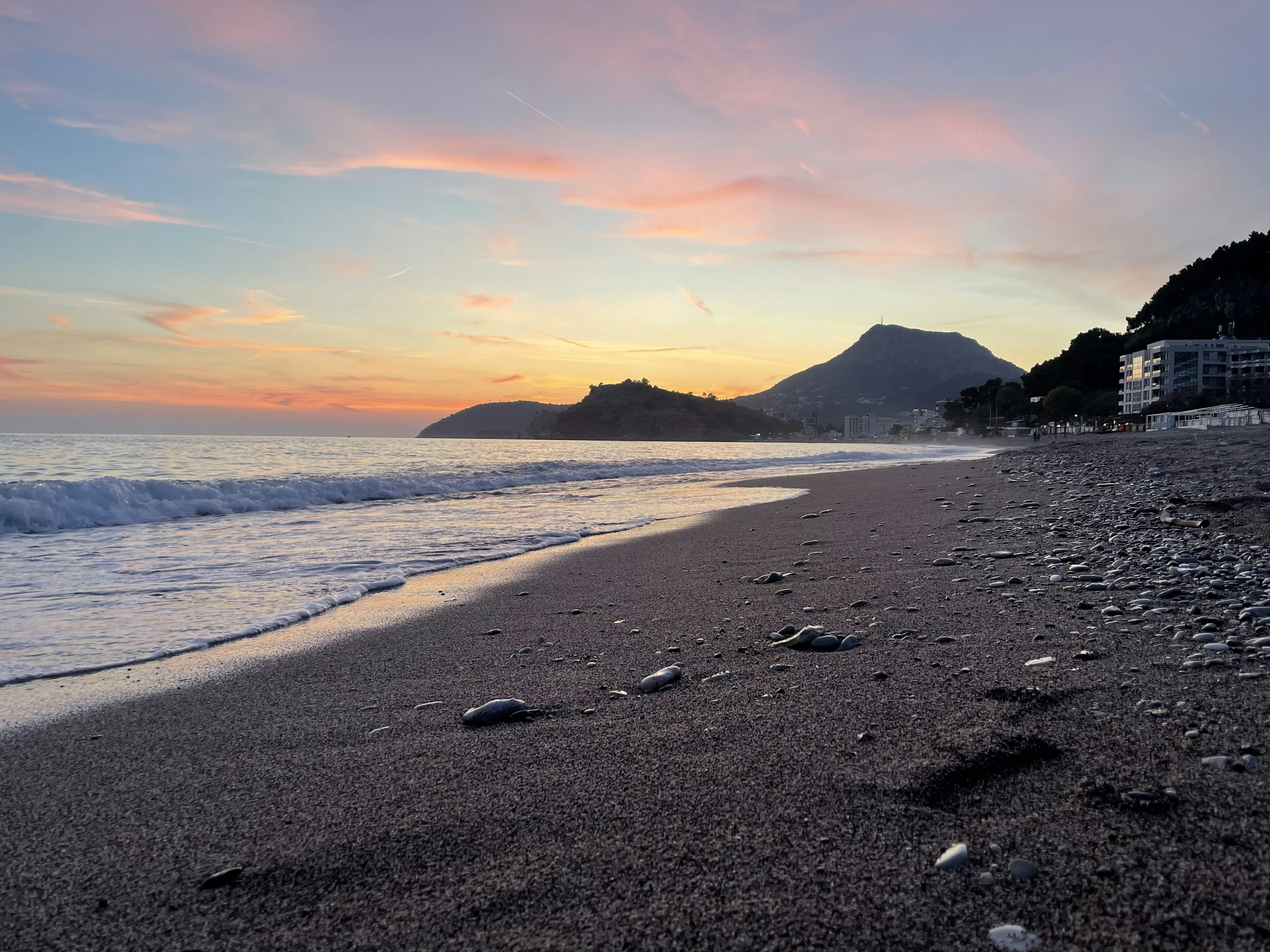 A sandy beach with waves coming in to shore photo – Free Sutomore Image ...