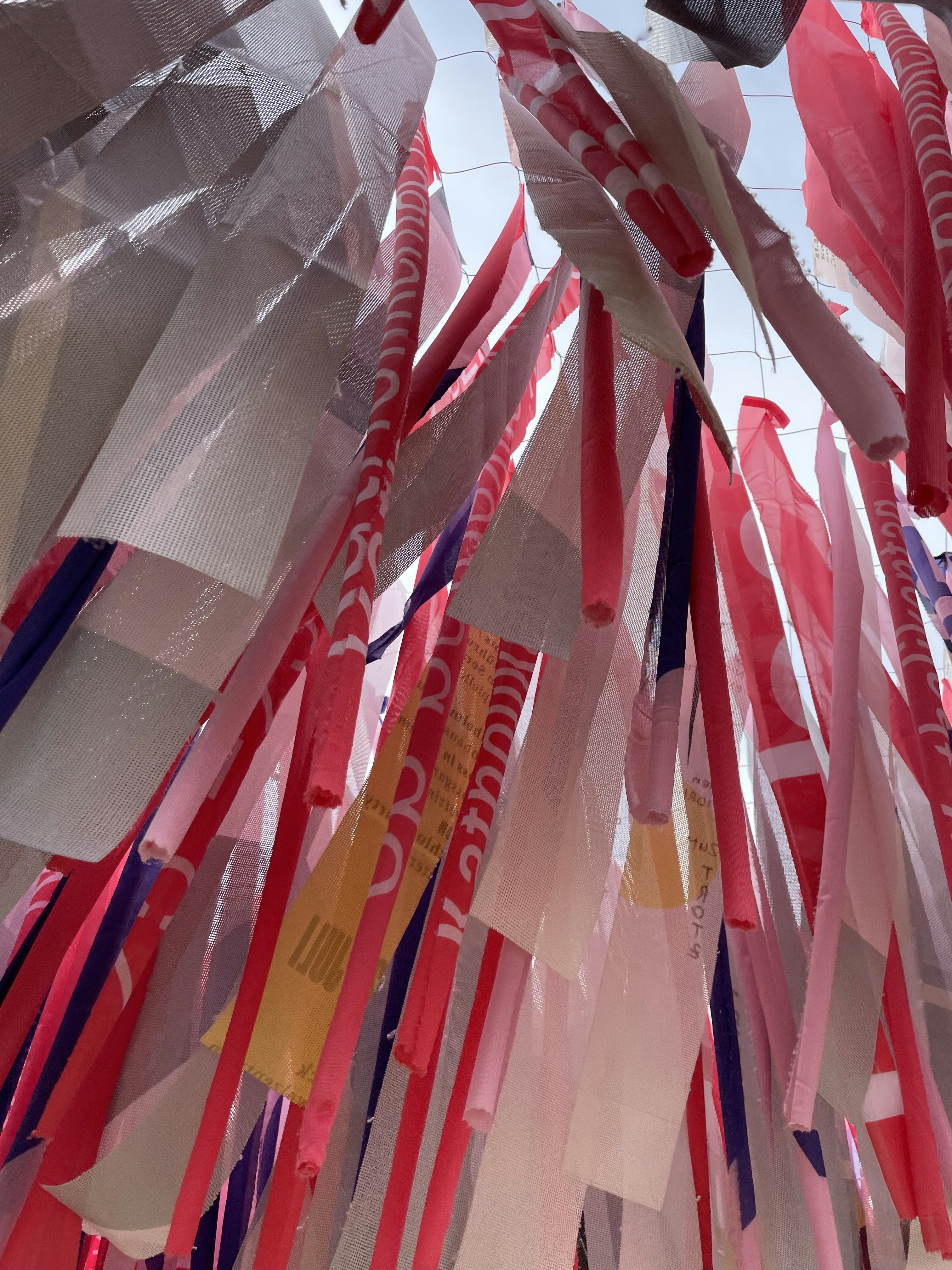 A bunch of colorful streamers hanging from a ceiling photo – Free ...