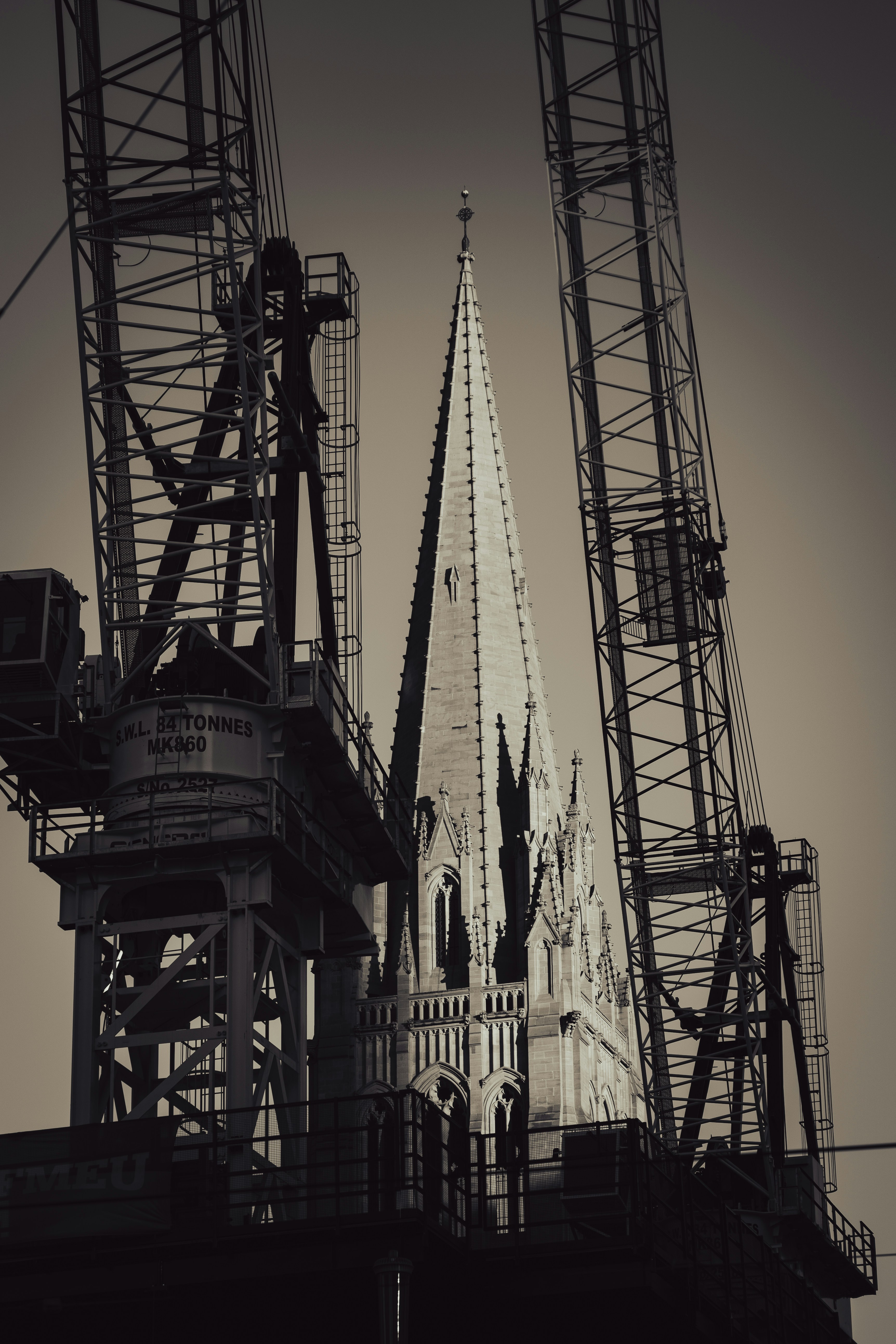 Gothic Spire Framed by Industrial Giants