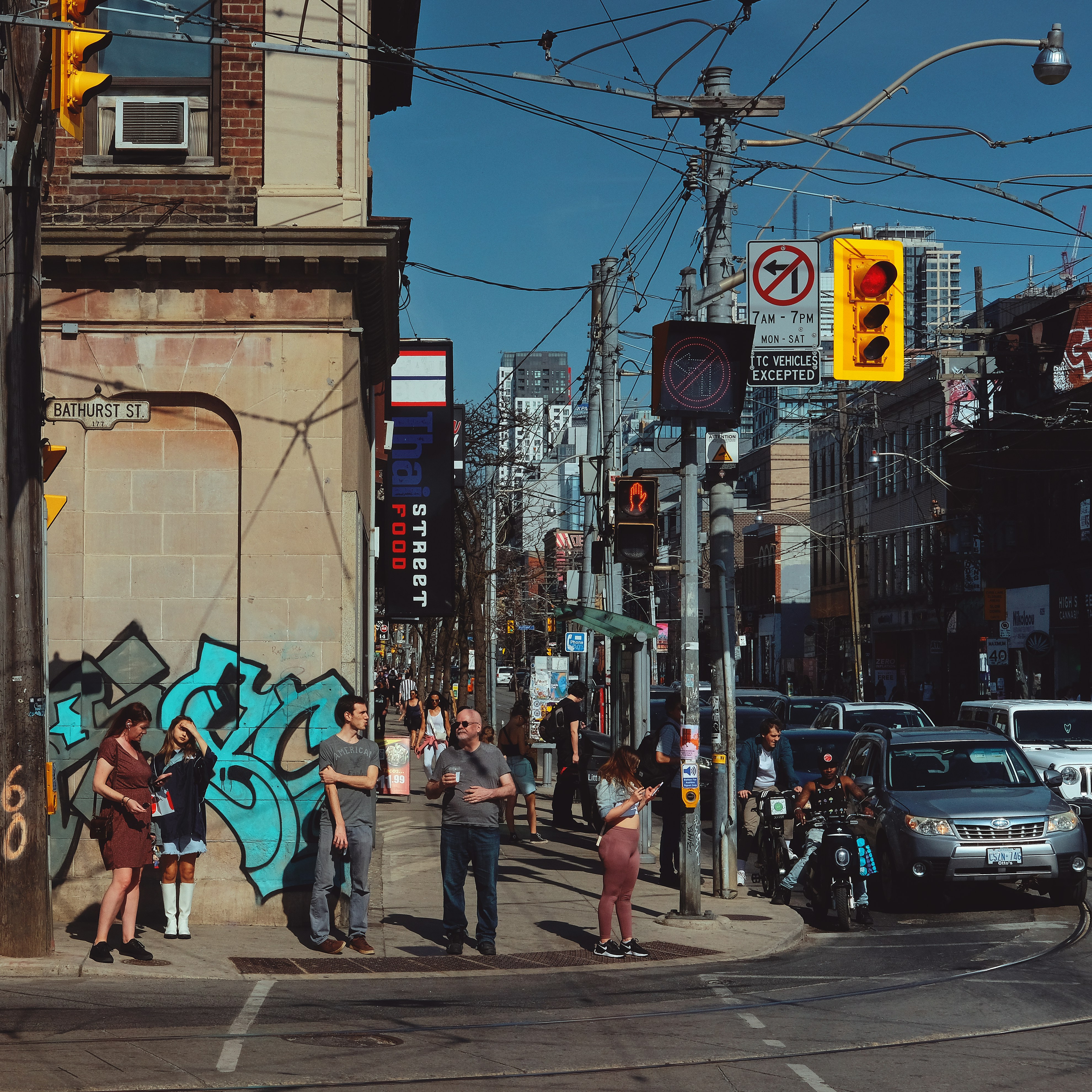 A group of people standing on a street corner photo – Free Downtown ...