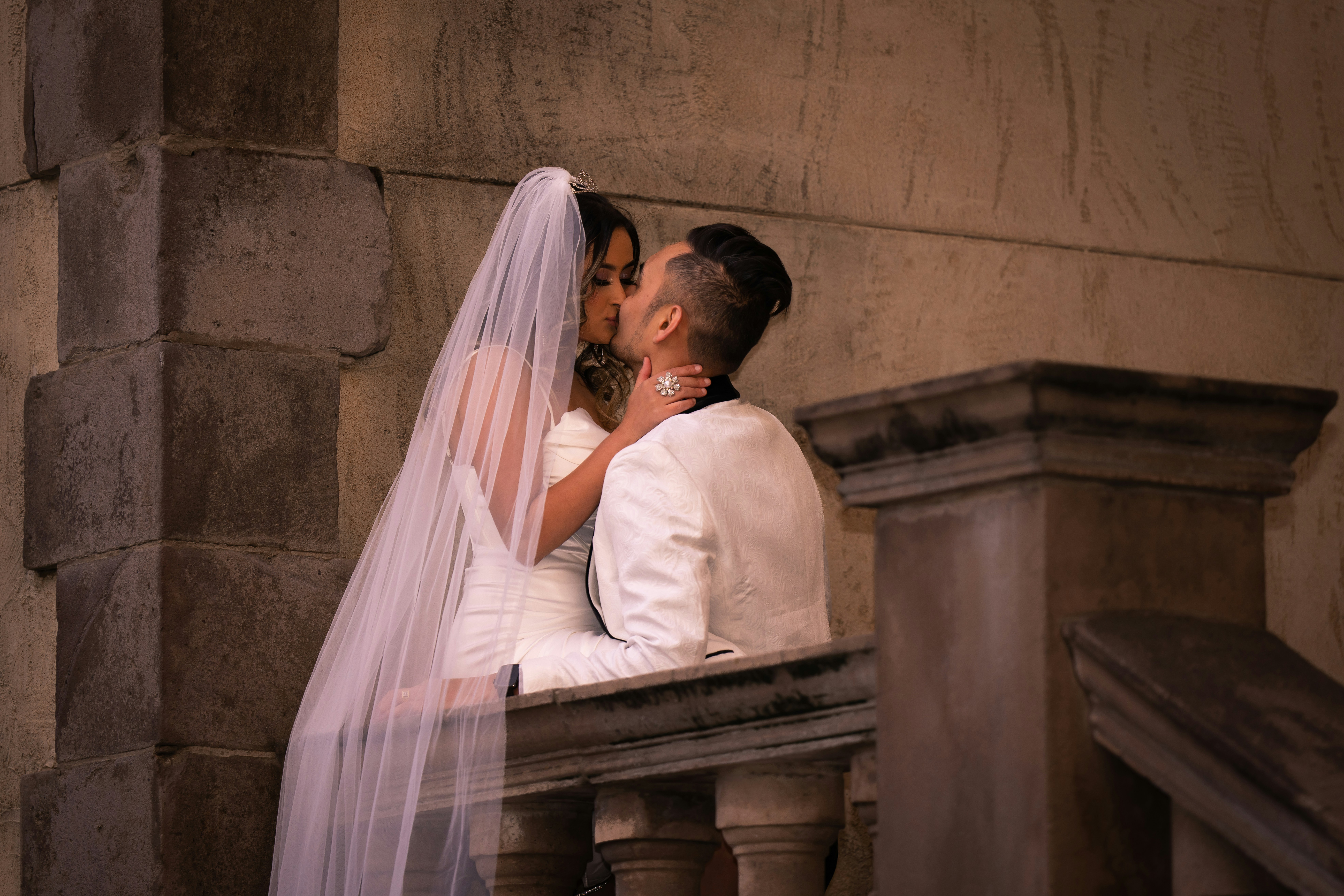Kiss on the Weathered Balcony: A Warm Wedding Moment