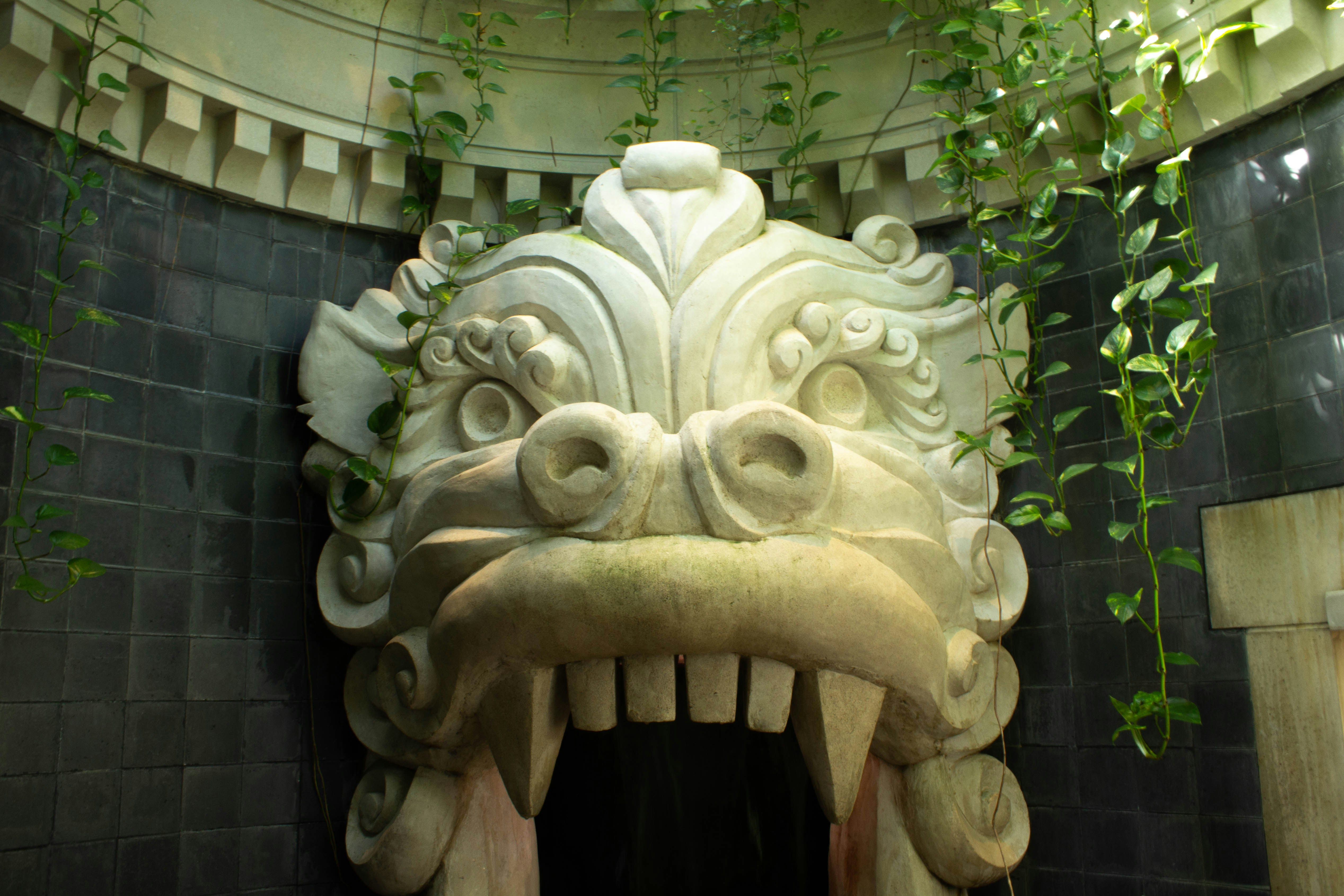 Guardian of the Entrance: Stone Beast Beneath Green Vines