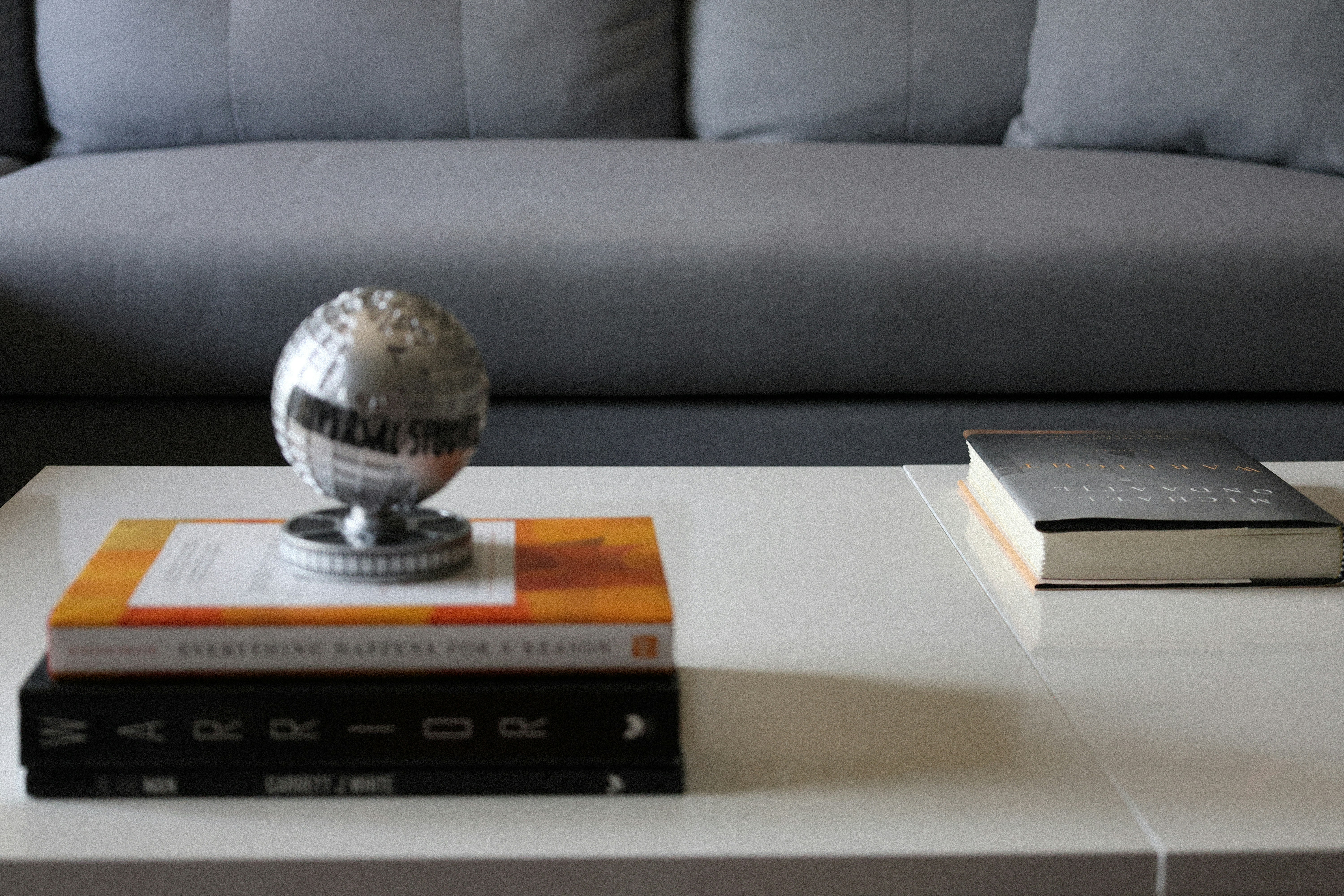 a table with a book and a silver ball on top of it