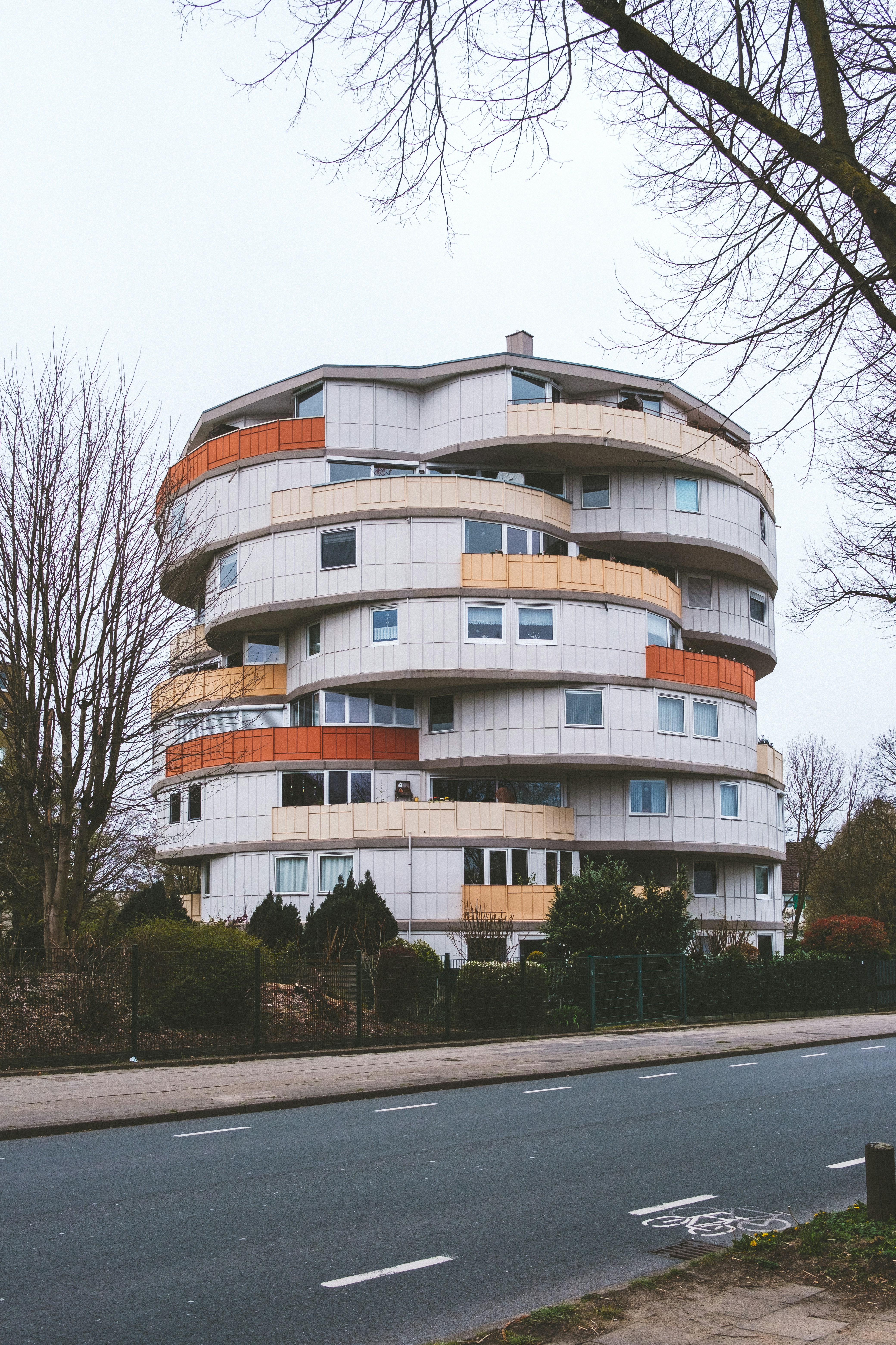 A tall building with a circular balcony next to a street photo – Free ...